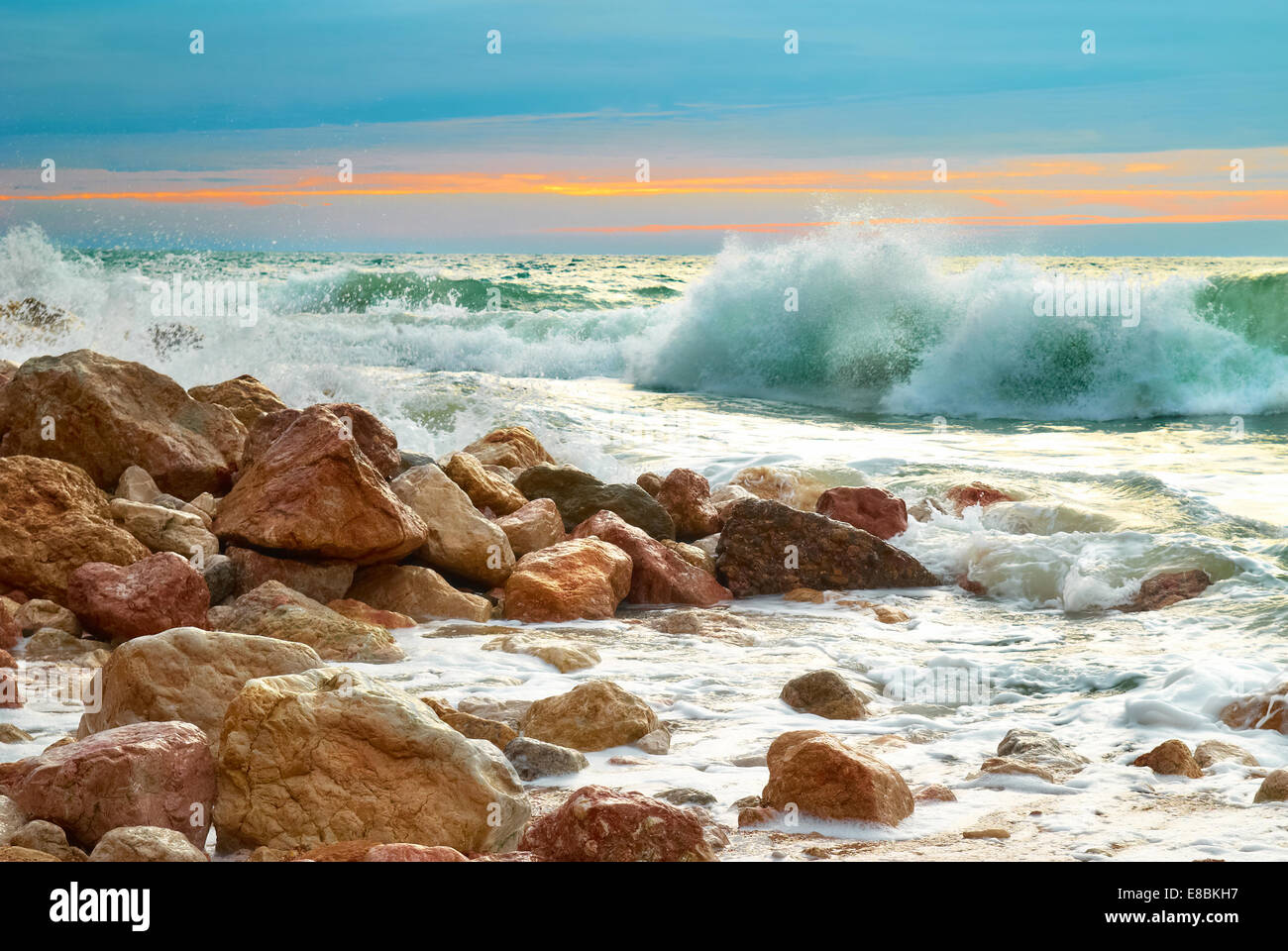 Sea landscape with waves on the beach against sunset Stock Photo - Alamy