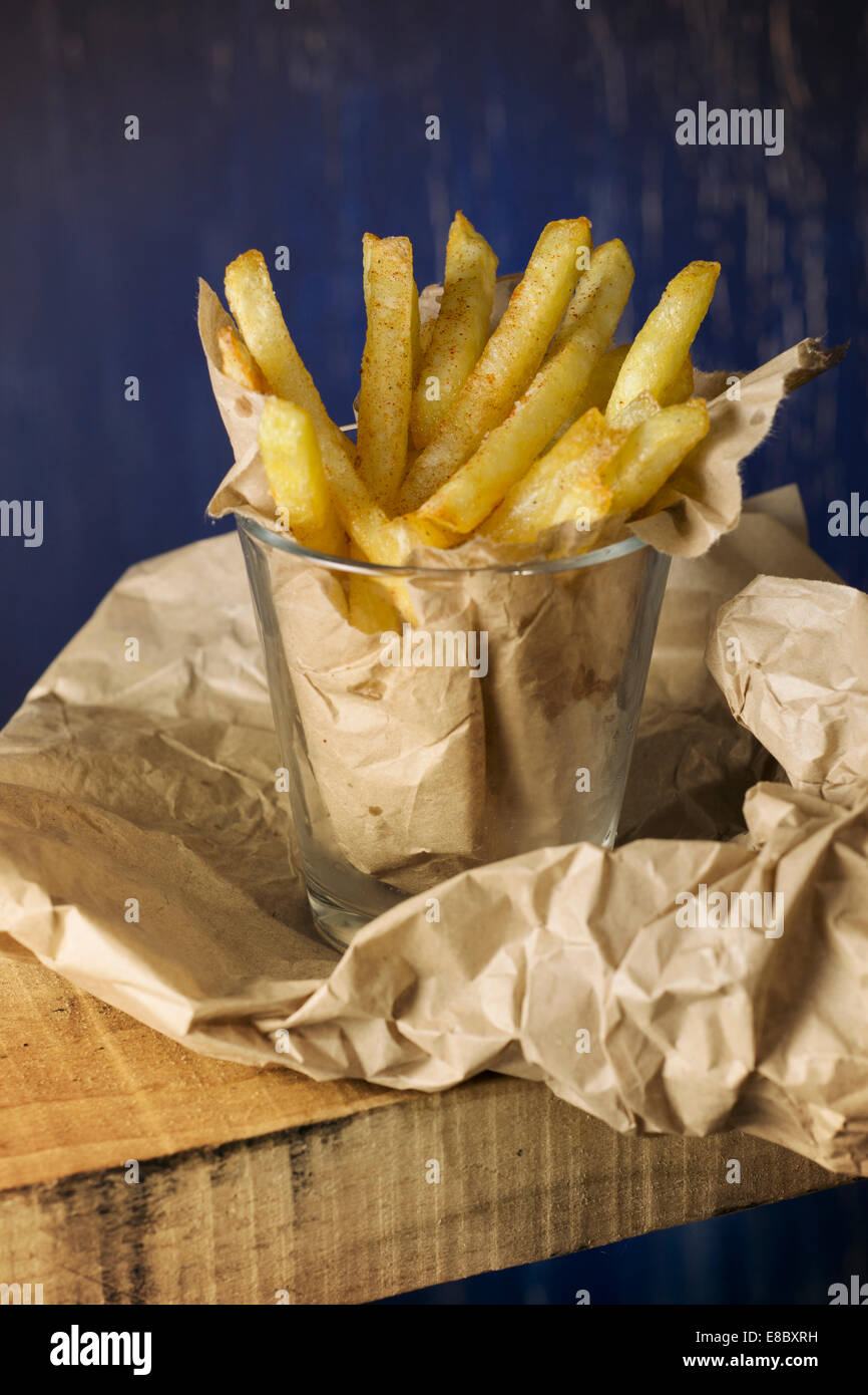 fries, homemade, wrapped in paper, on wood and blue background Stock ...