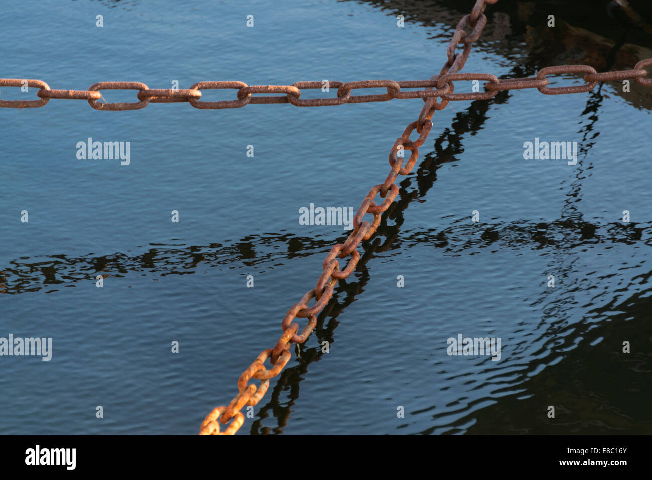Rusty chains mirrored in the water Stock Photo - Alamy