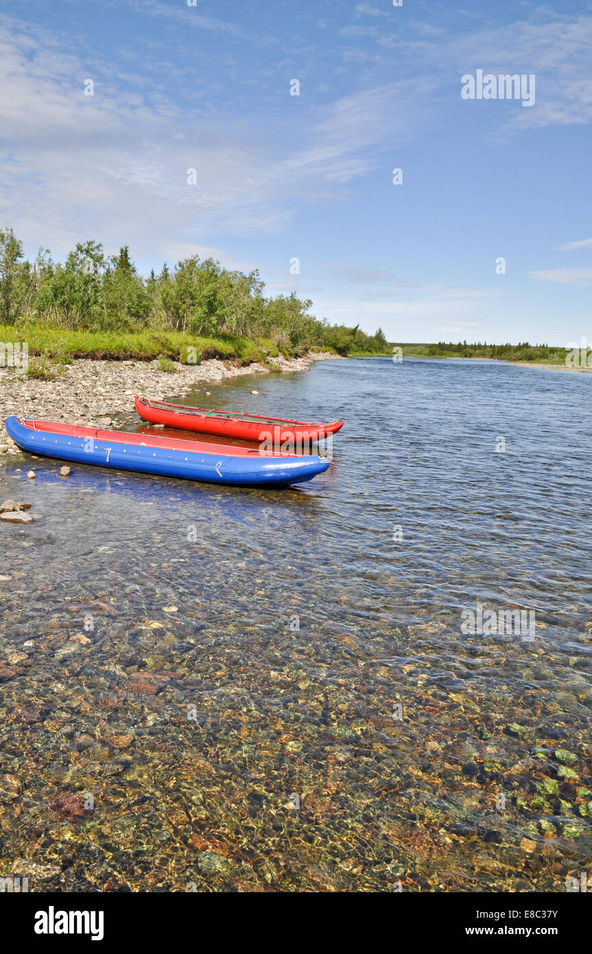 Two inflatable canoes on the shore of the North river. Polar Ural, Komi ...