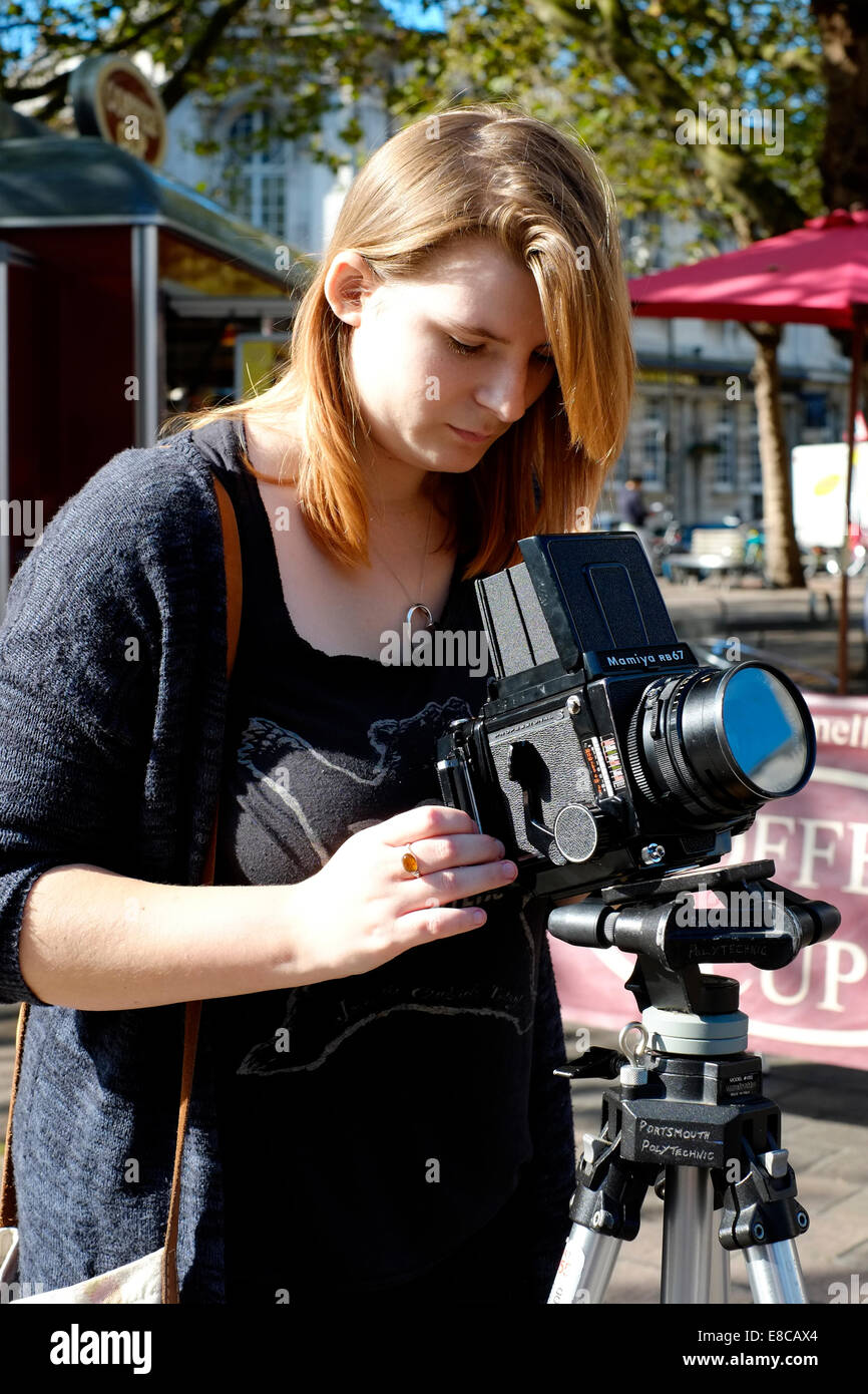 young female photography student learning to use a medium format roll ...