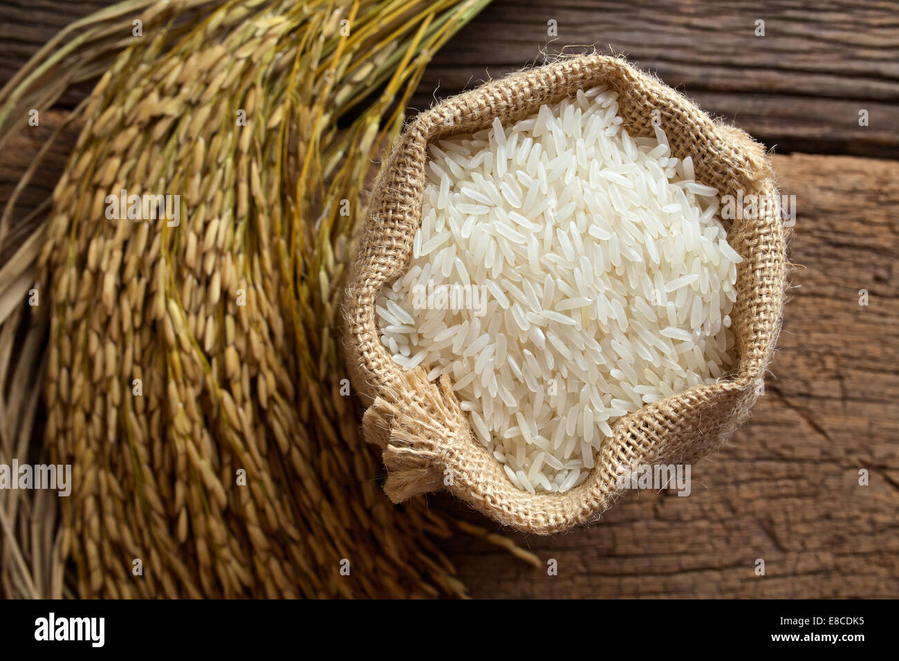 white rice in burlap sack with rice grain Stock Photo - Alamy