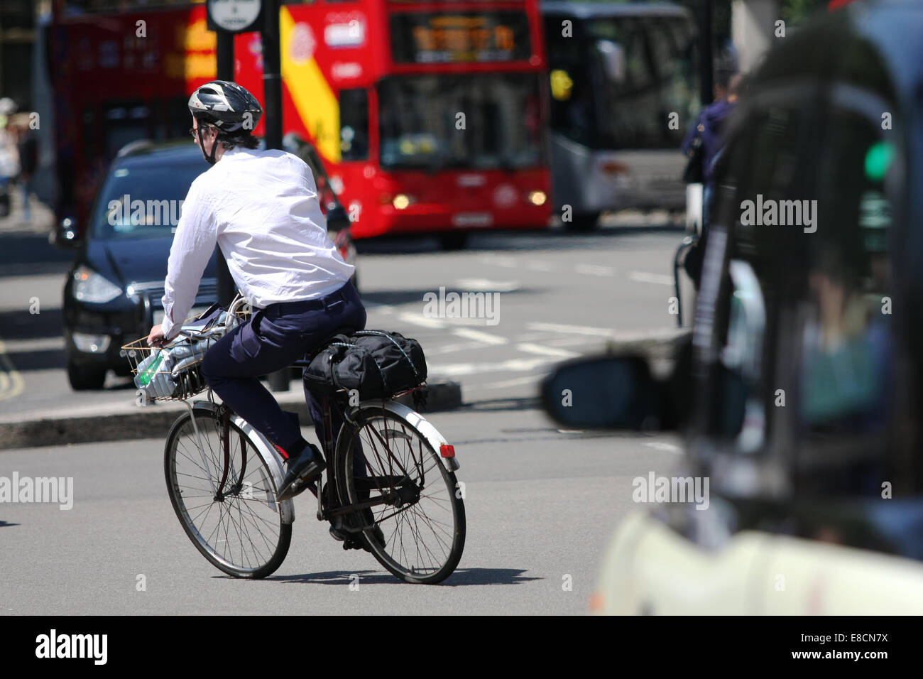 A male cyclist turning left on a road in London, England Stock Photo ...