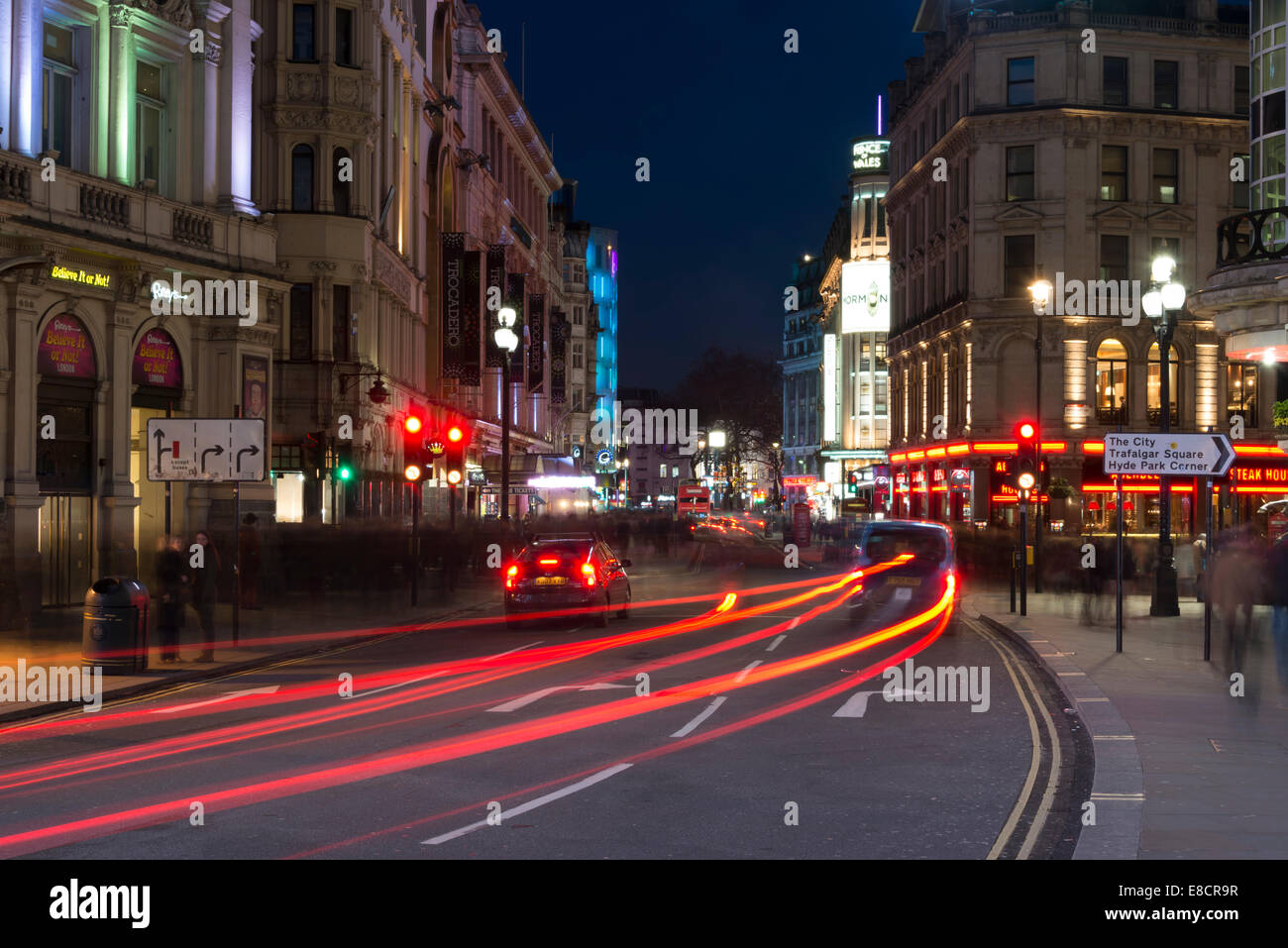 A car and black cab stop at a red light in central London making light ...