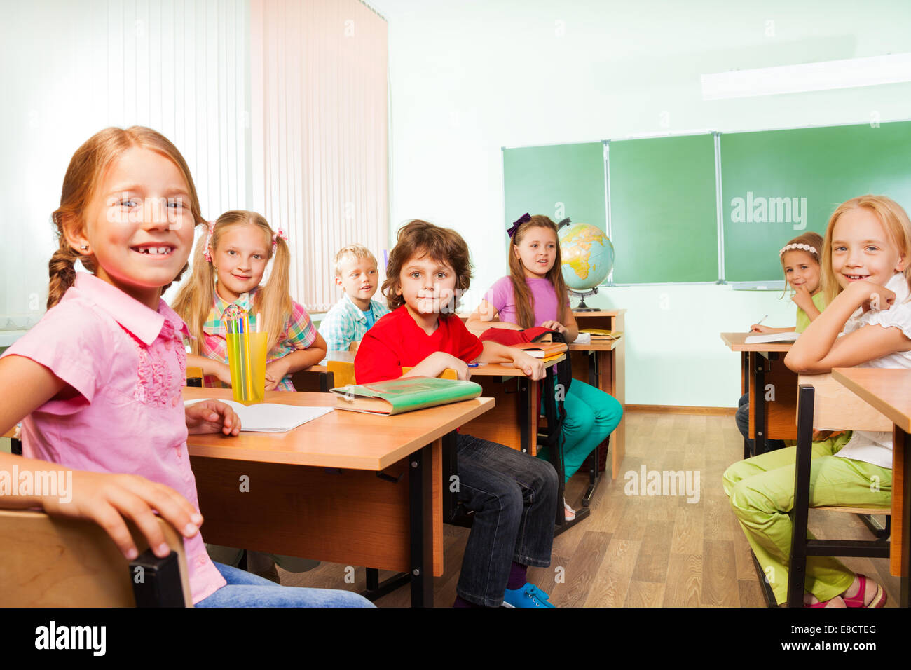 Desk rows with boys and girls sitting in classroom Stock Photo - Alamy