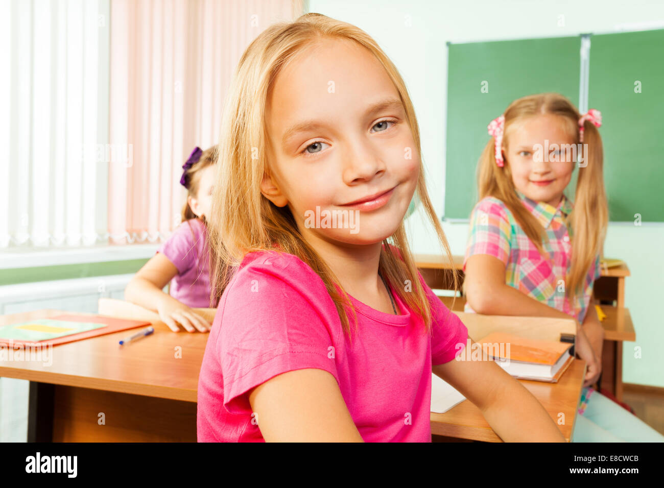 Cute girl looking sitting in classroom Stock Photo - Alamy