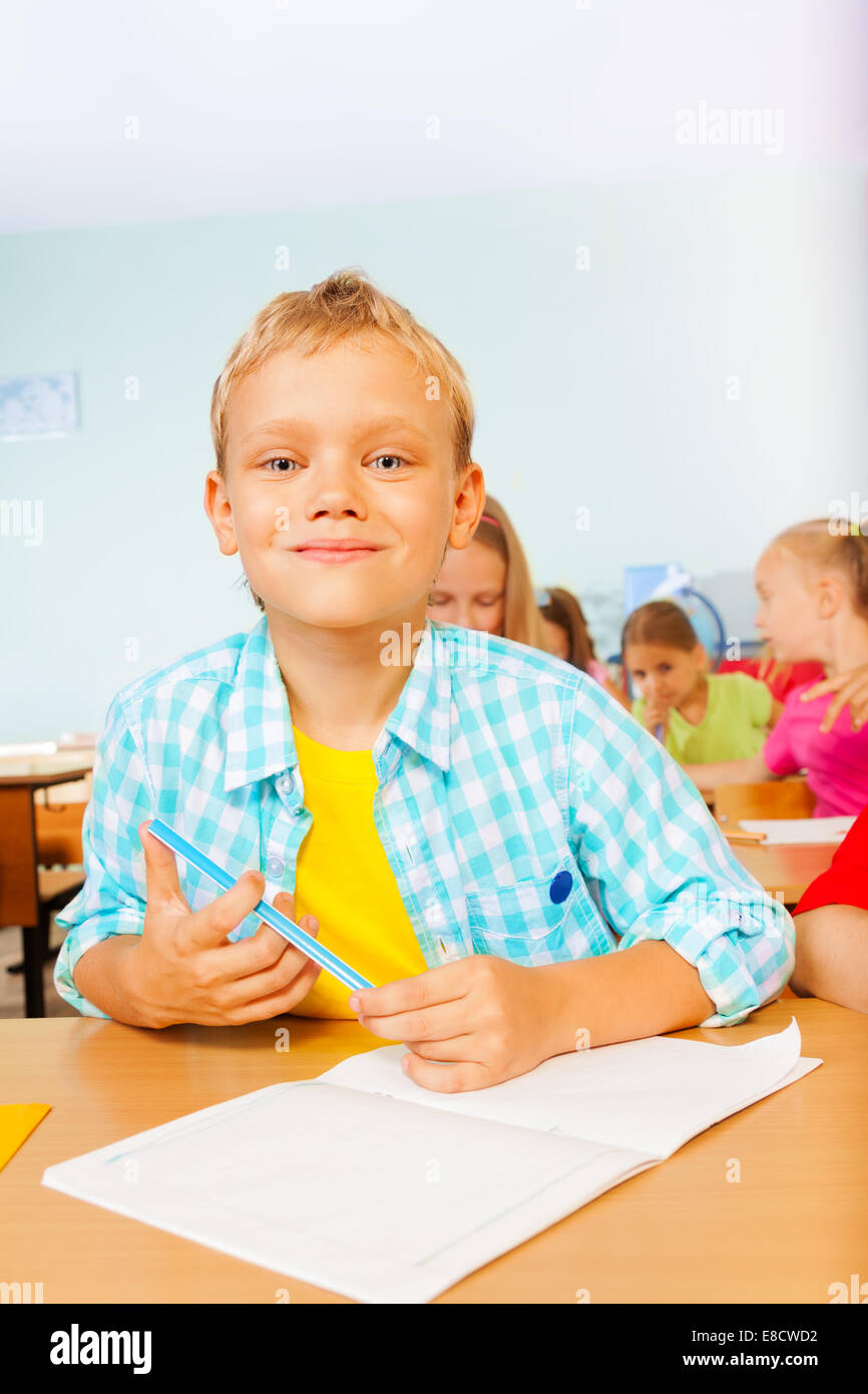 Smiling boy looks while writing in exercise book Stock Photo - Alamy