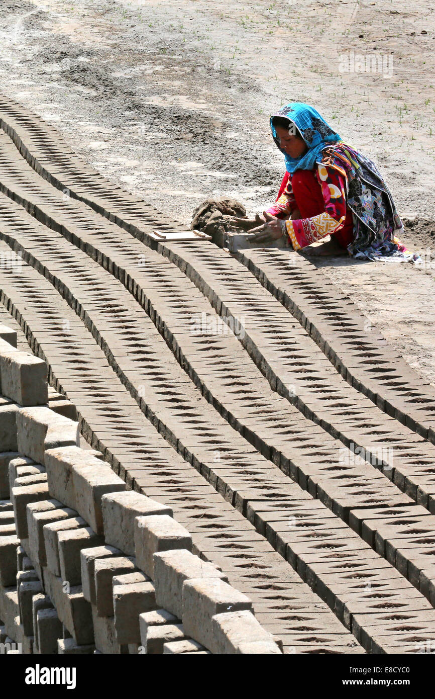 female brickyard worker form clay bricks on a field of the Patoki Brick ...