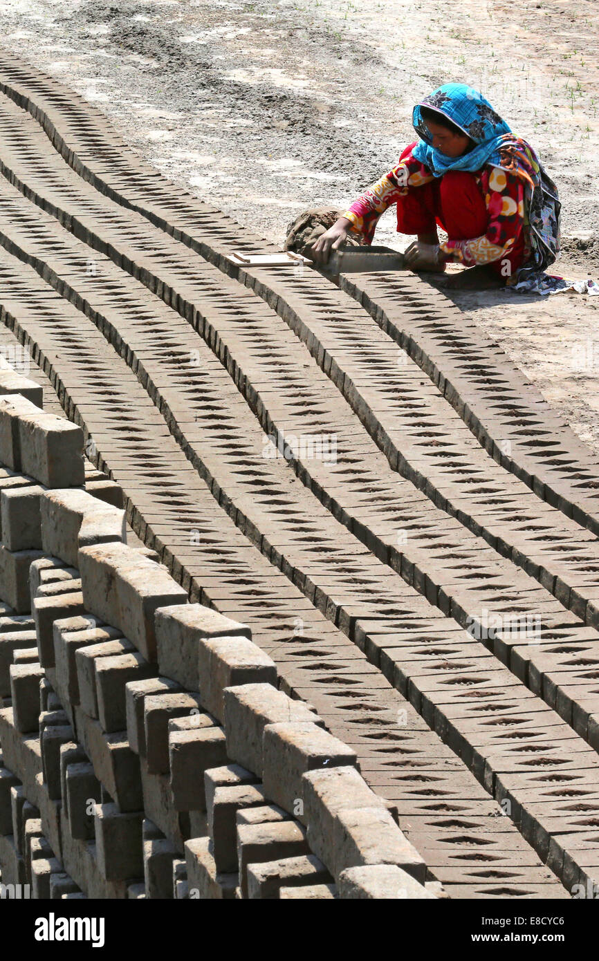 female brickyard worker form clay bricks on a field of the Patoki Brick ...