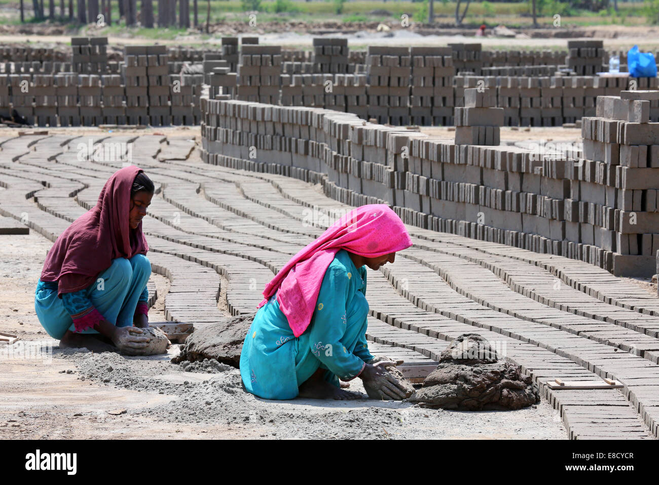female brickyard worker form clay bricks on a field of the Patoki Brick ...