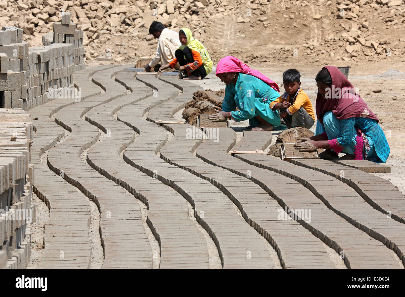 female brickyard worker form clay bricks on a field of the Patoki Brick ...
