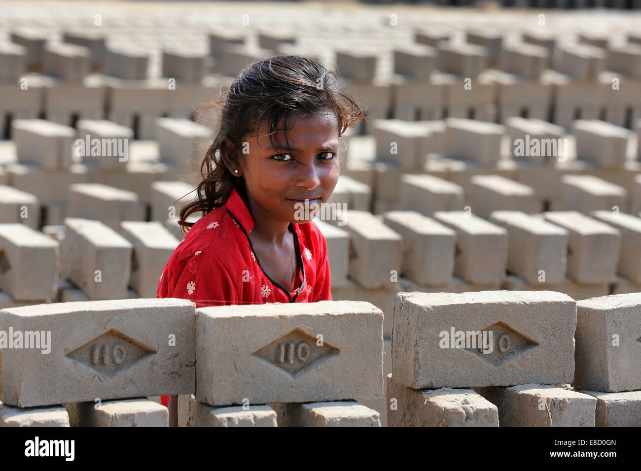 Brickyard worker (9 years old) form clay bricks on a field of the ...