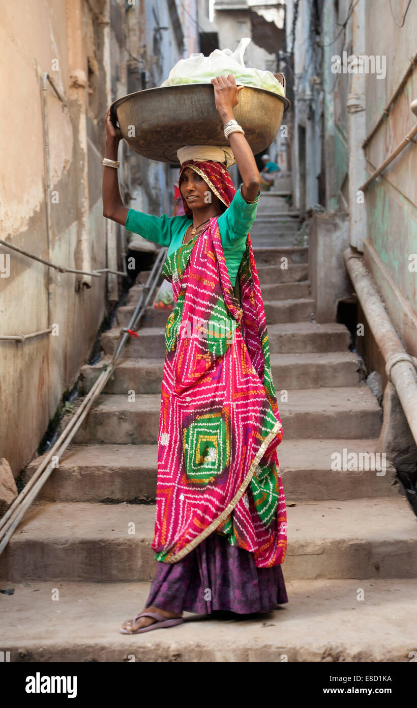 Indian woman carrying heavy load from market in the holy town of ...