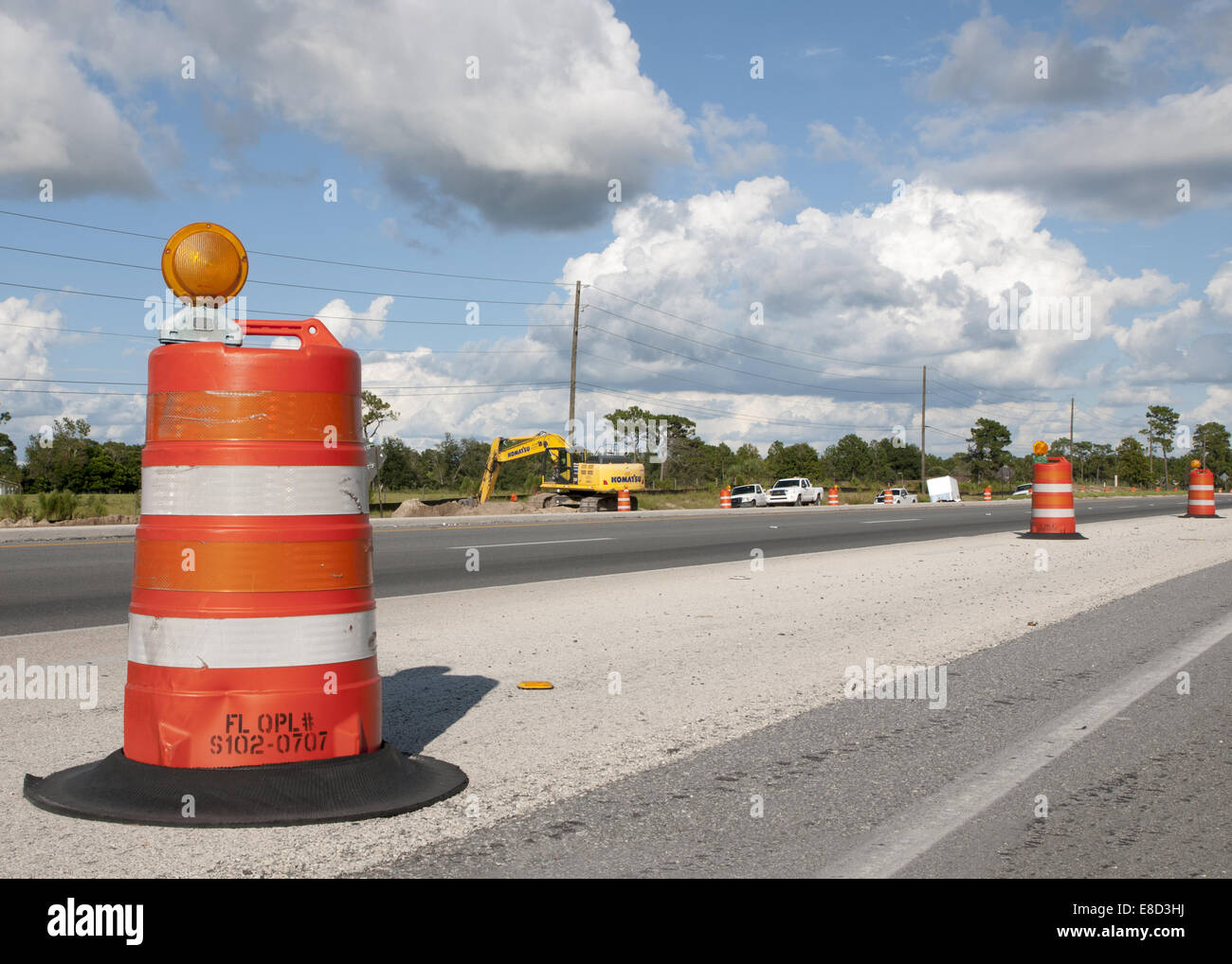 Orange barrell barrier for road construction. Front end loader across ...