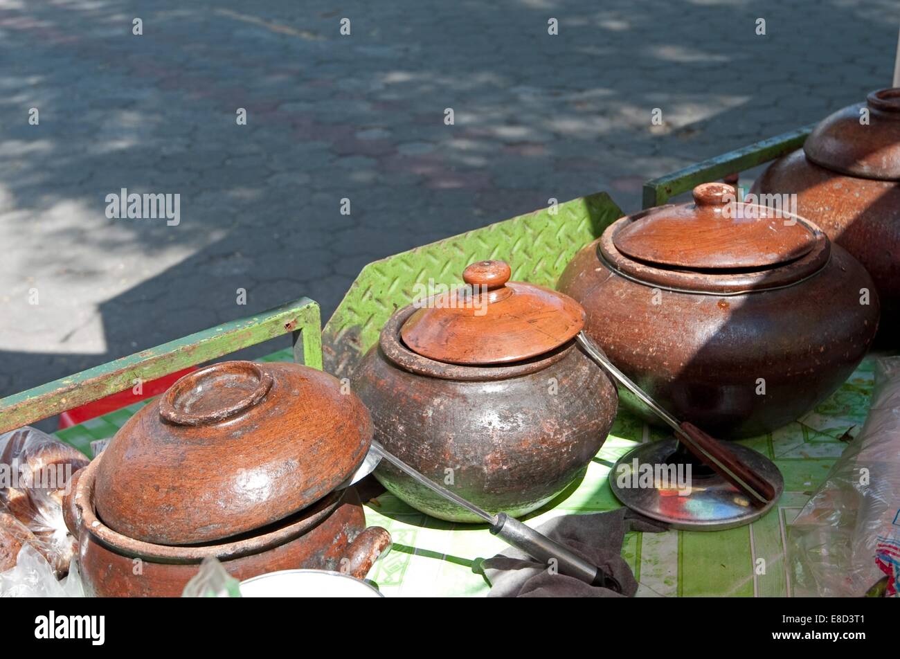 Lunchtime food in line of terracotta pots on street side vendors stall ...