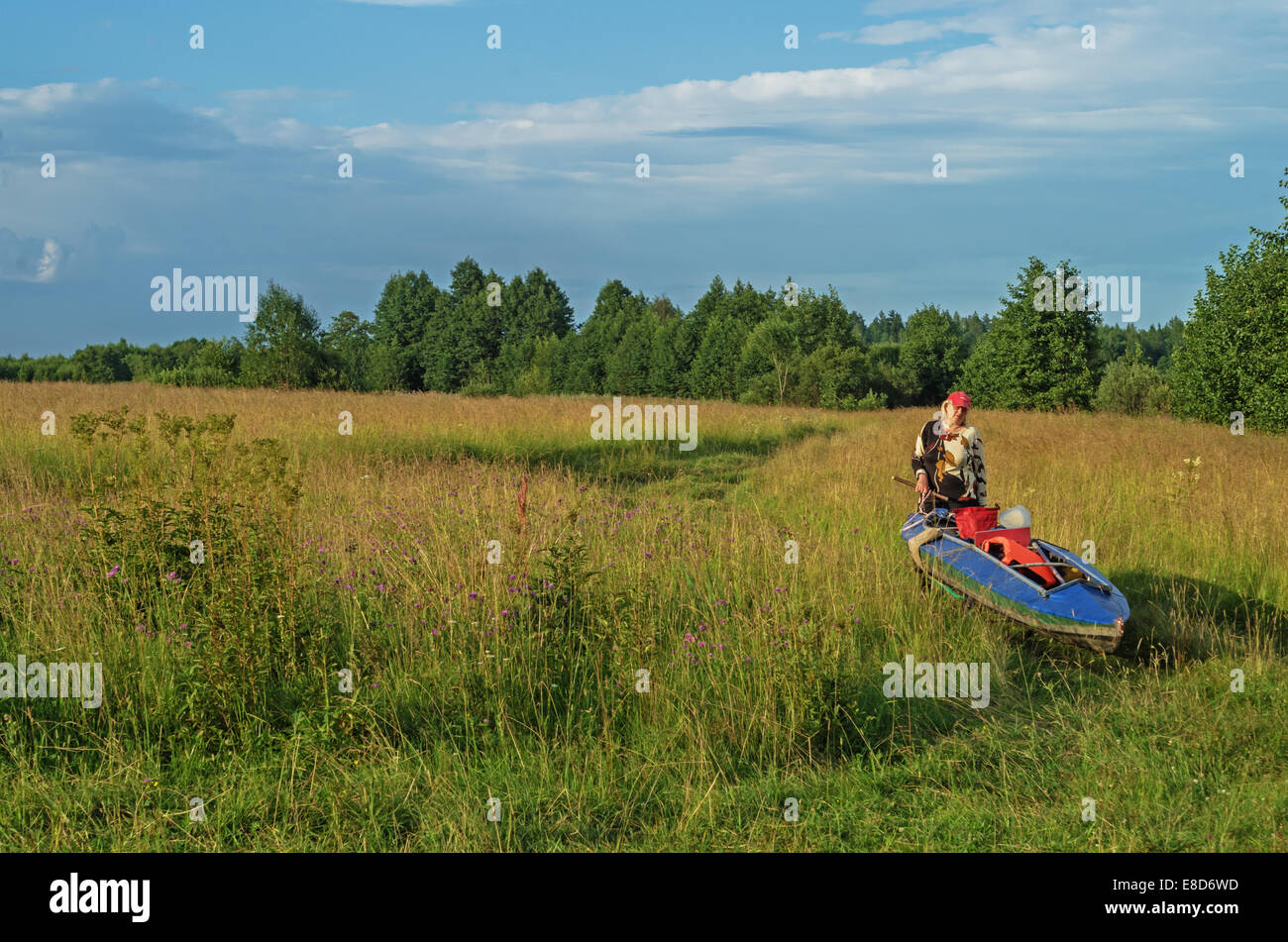 Canoe travel on grass road to forest lake Stock Photo - Alamy