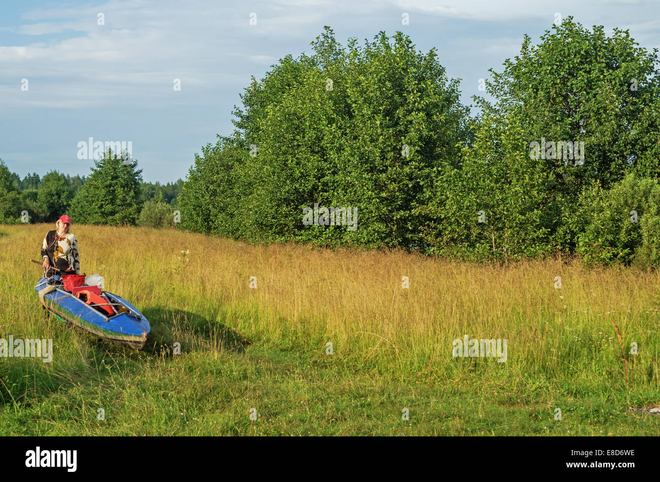 Canoe travel on grass road to forest lake Stock Photo - Alamy