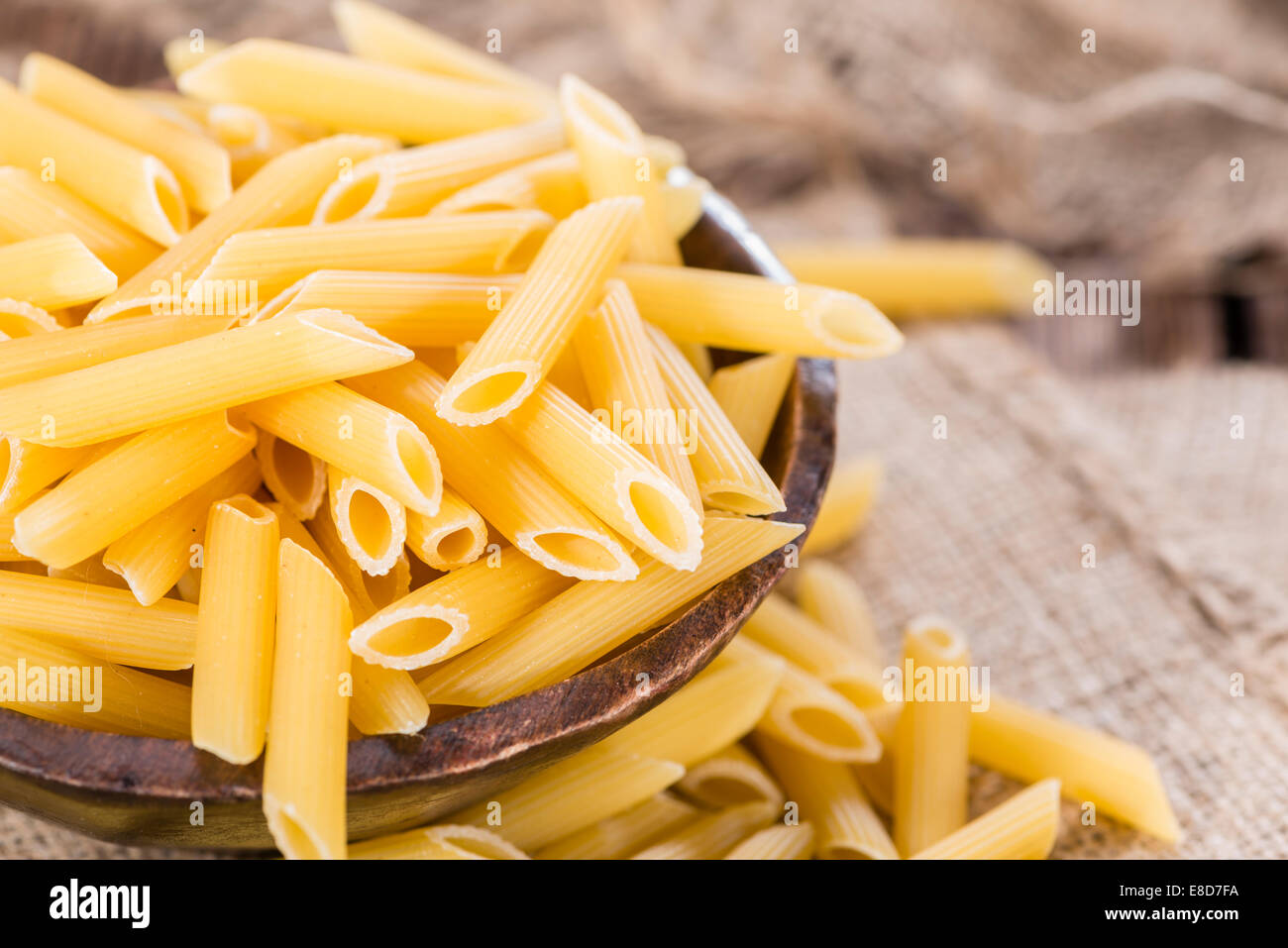 Raw Penne on rustic wooden background (detailed close-up shot Stock ...