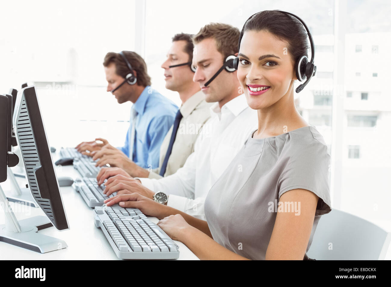 Business people with headsets using computers in office Stock Photo - Alamy