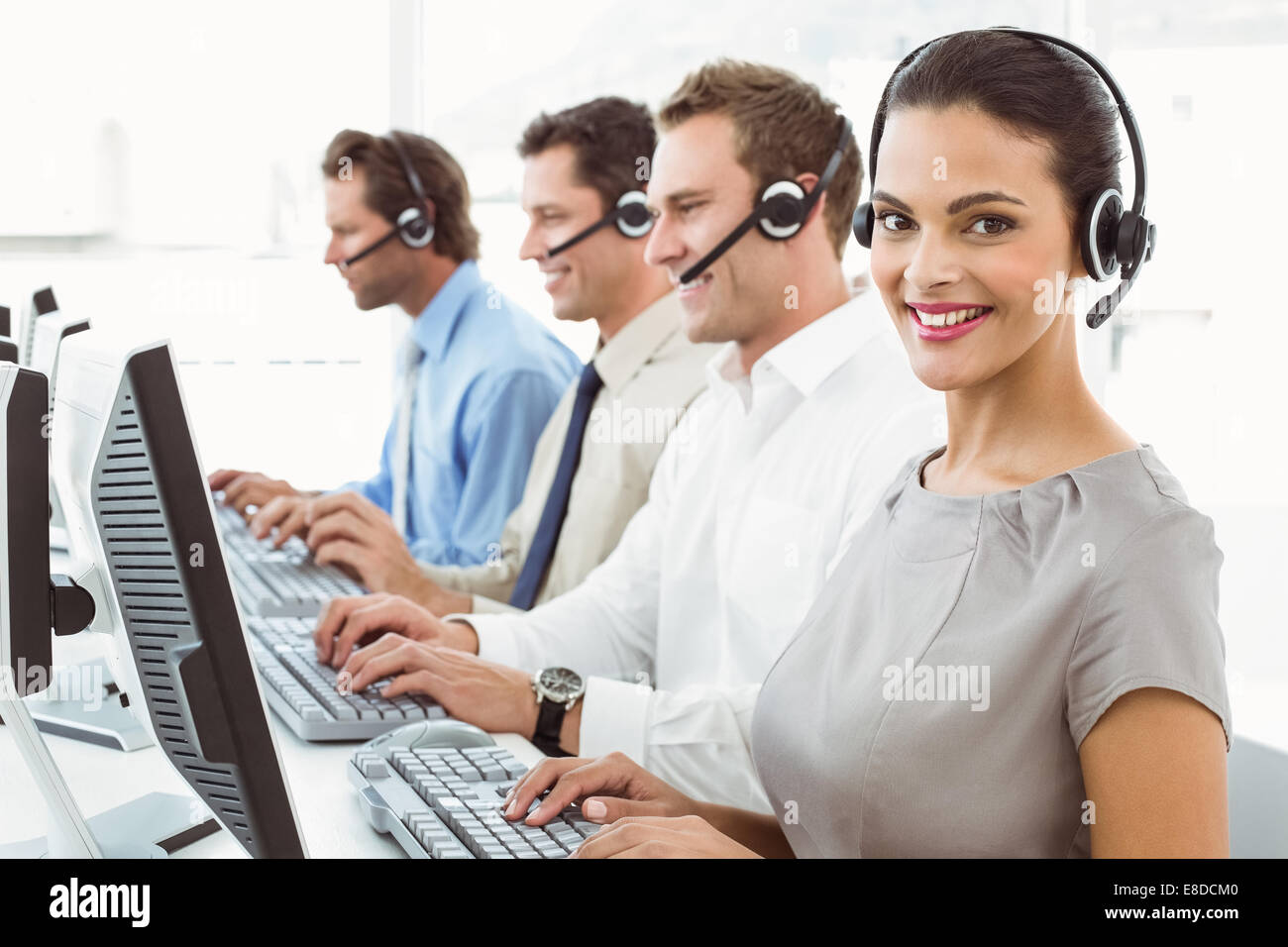 Business people with headsets using computers in office Stock Photo - Alamy