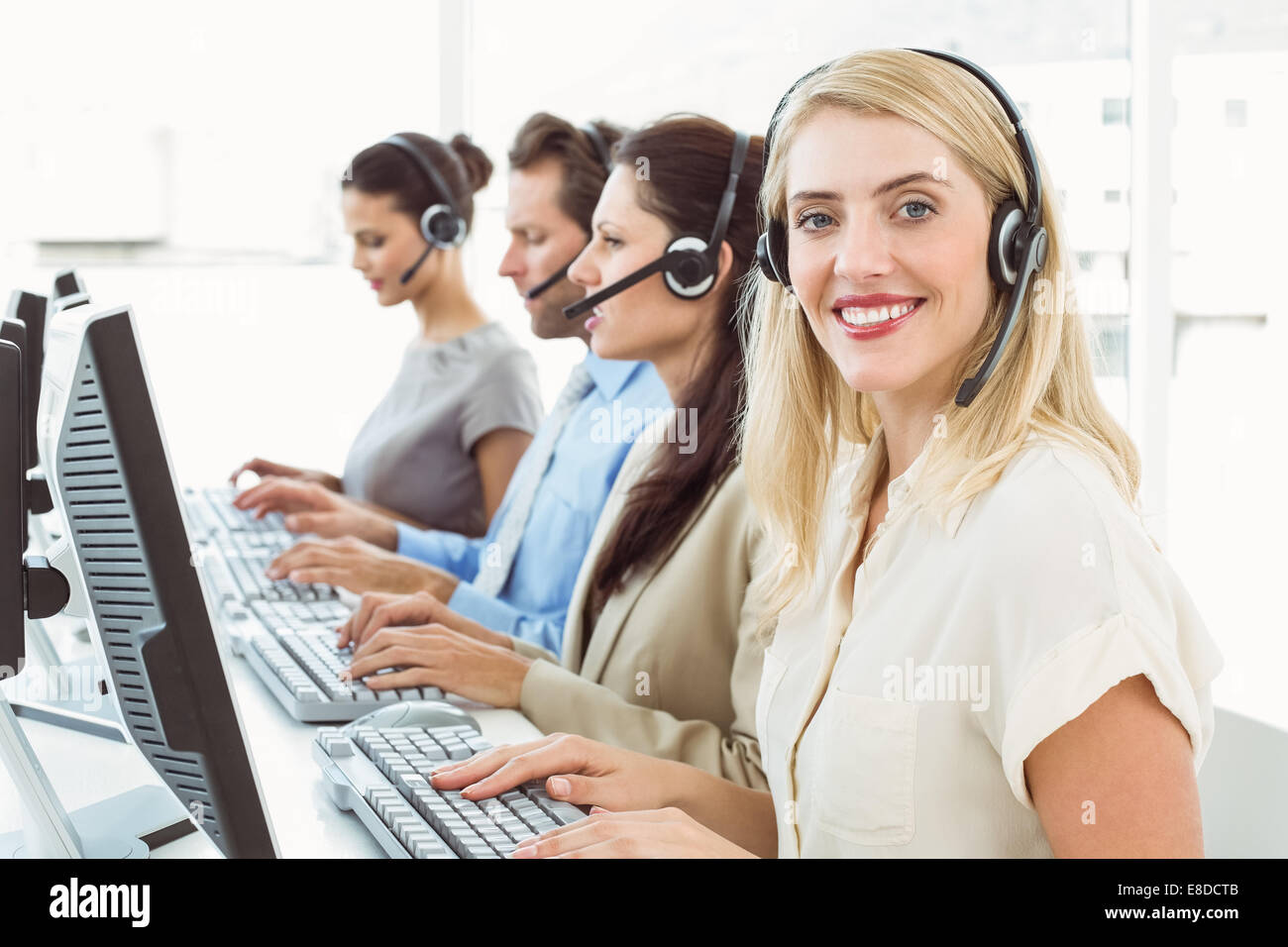 Business people with headsets using computers in office Stock Photo - Alamy