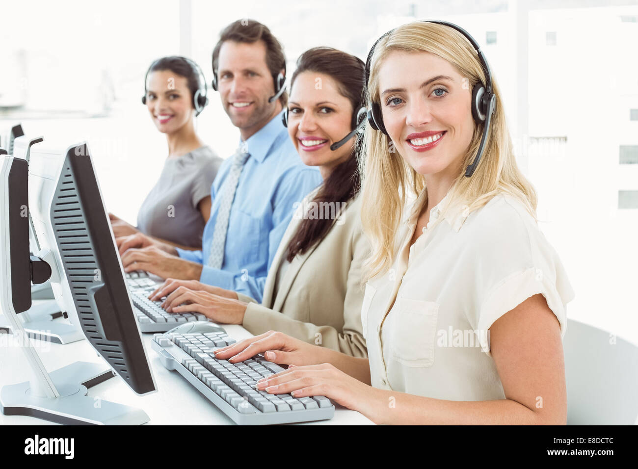 Business people with headsets using computers in office Stock Photo - Alamy