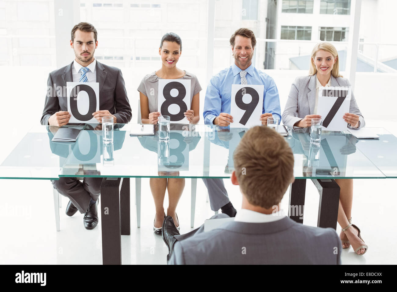 Interview panel holding score cards in office Stock Photo - Alamy