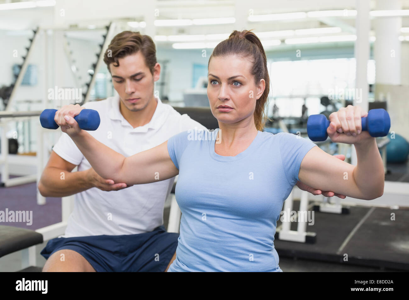 Personal trainer working with client on exercise ball Stock Photo - Alamy