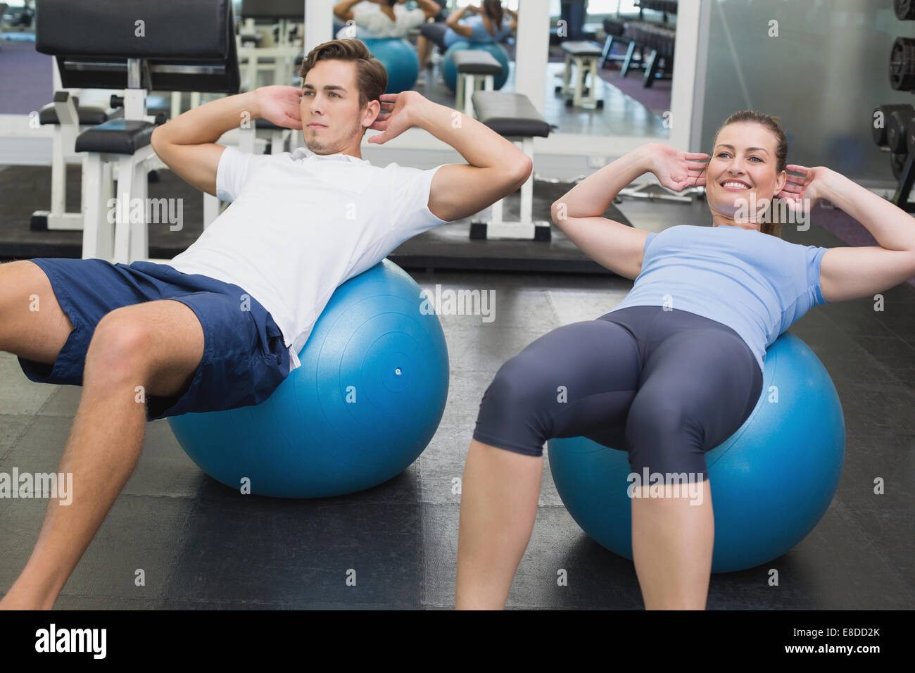 Couple doing sit ups on exercise balls Stock Photo - Alamy