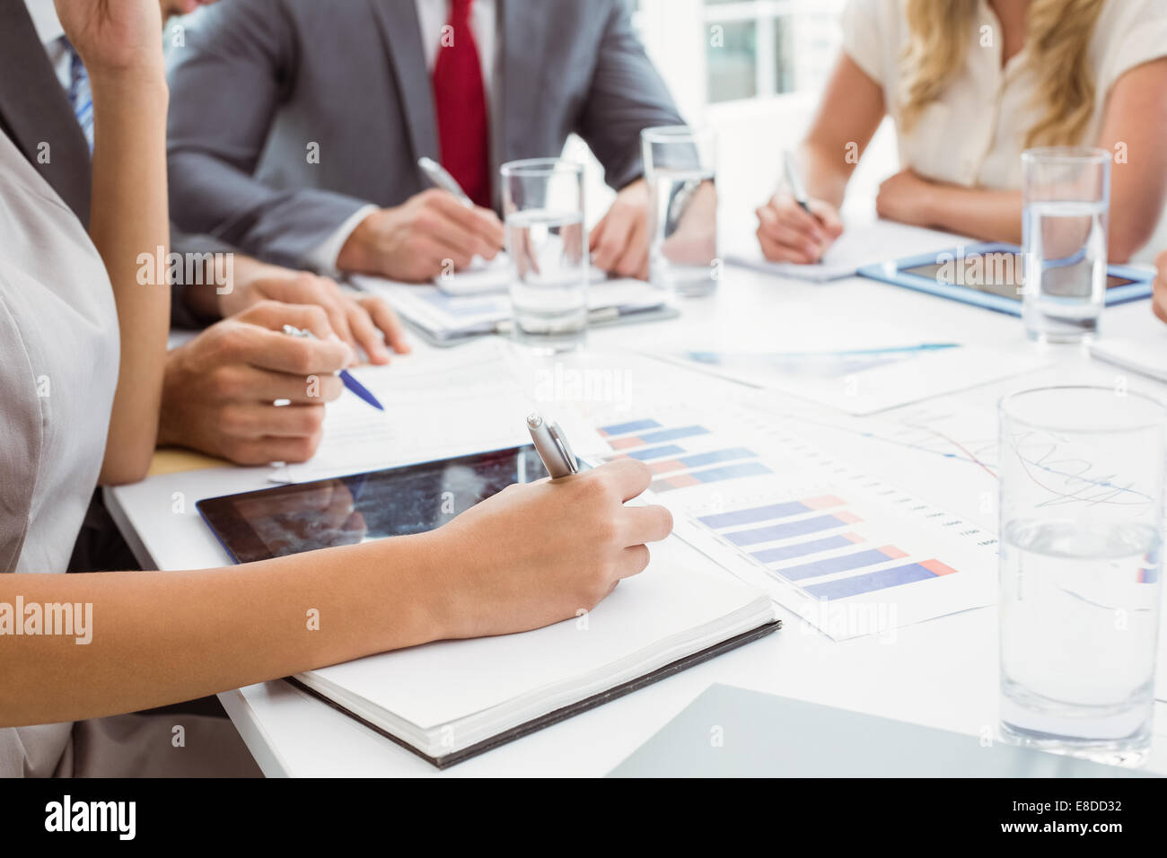 Mid section of executives writing notes in board room meeting Stock ...