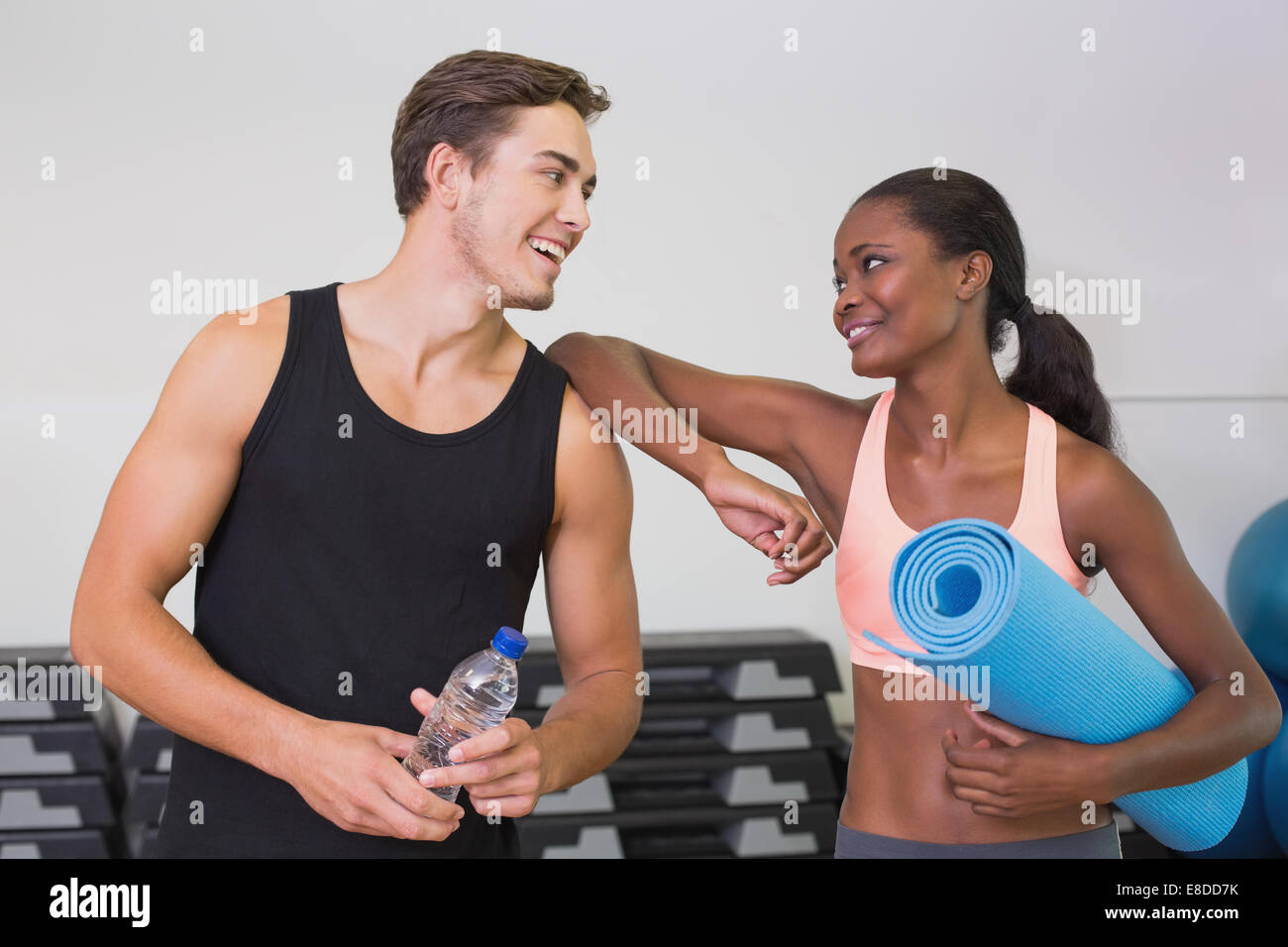 Personal trainer and client smiling at each other Stock Photo - Alamy