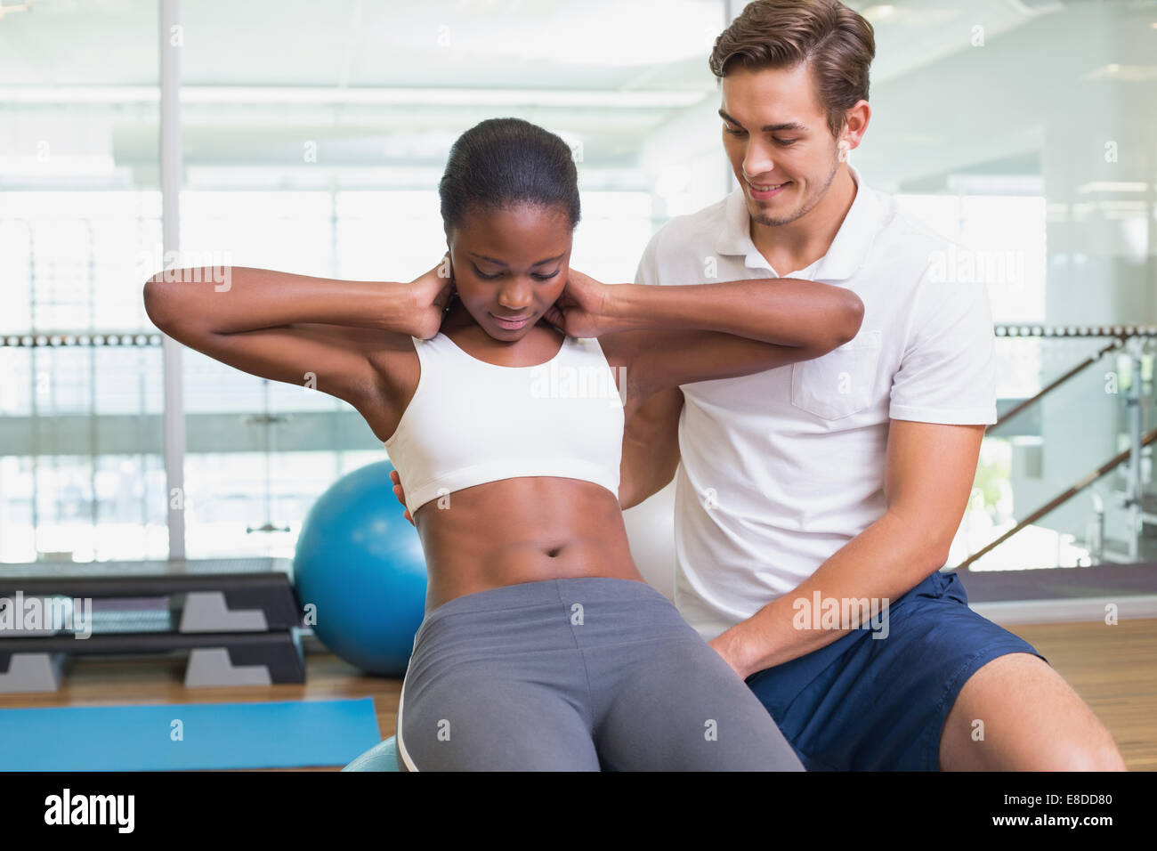 Personal trainer working with client on exercise ball Stock Photo - Alamy