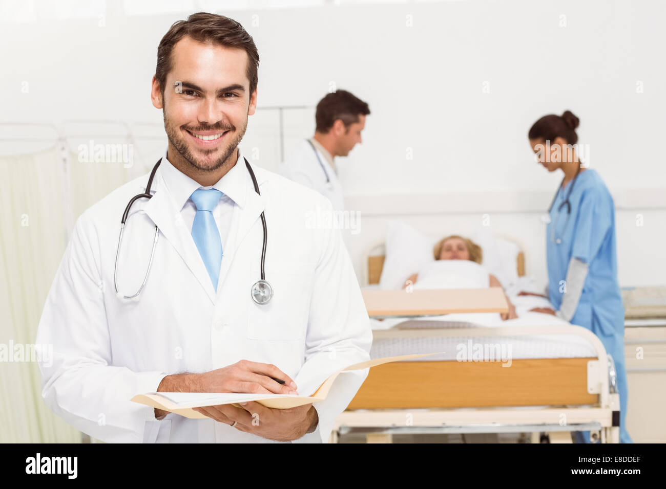 Doctor with colleagues and patient behind Stock Photo - Alamy