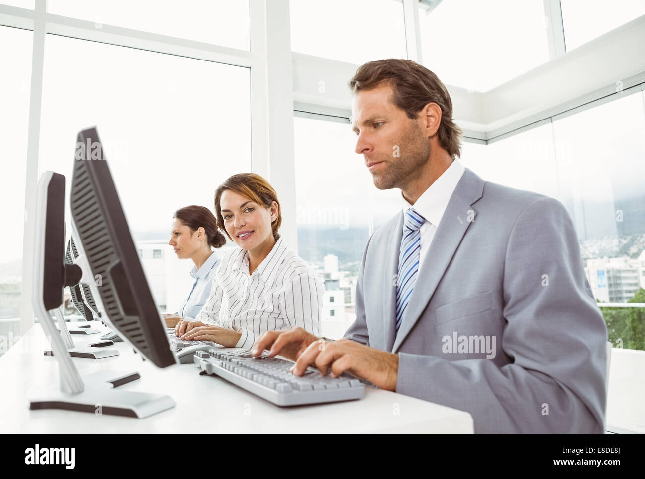 Business people with headsets using computers in office Stock Photo - Alamy