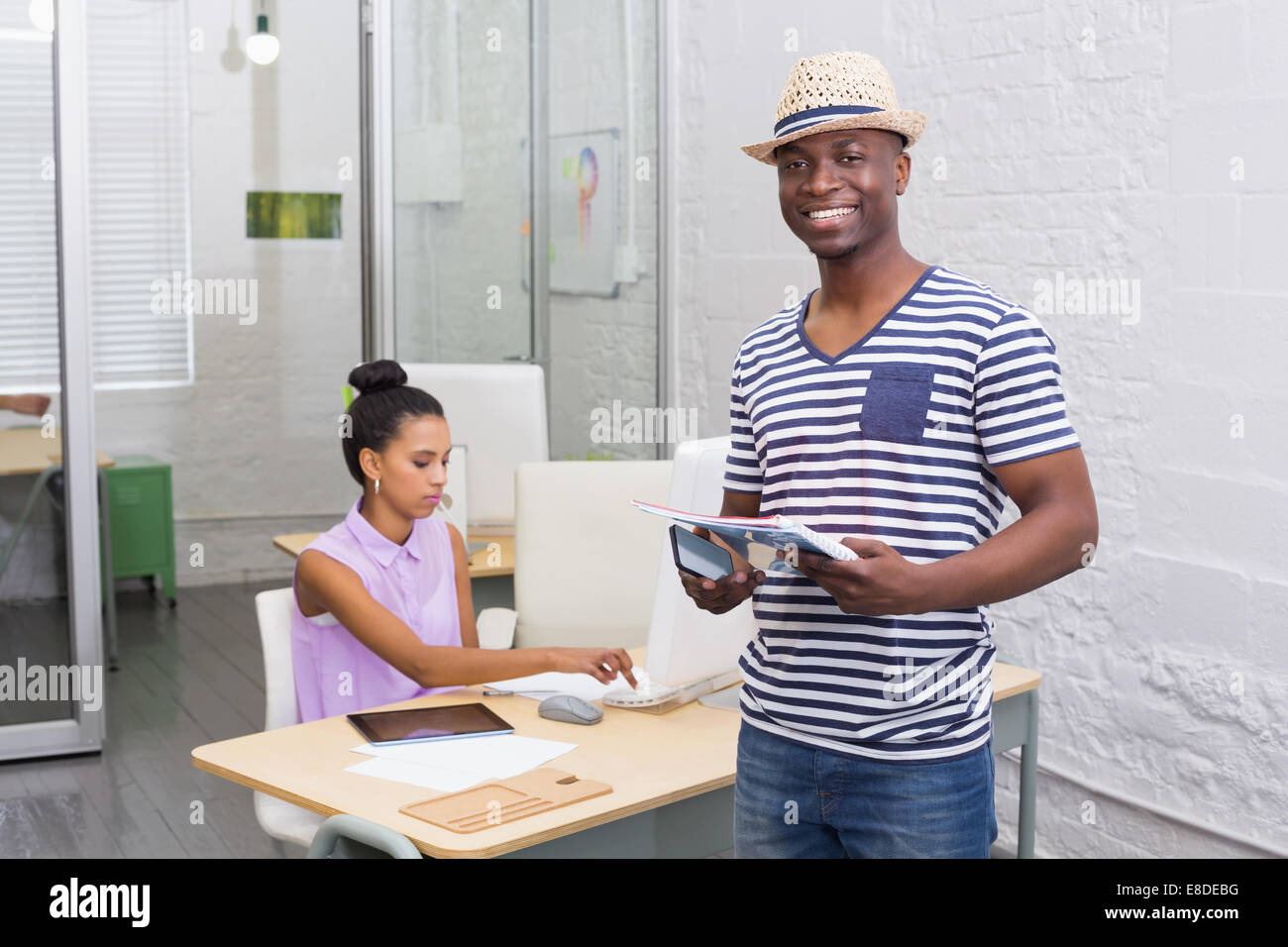 Casual man with colleague using computer behind in office Stock Photo ...