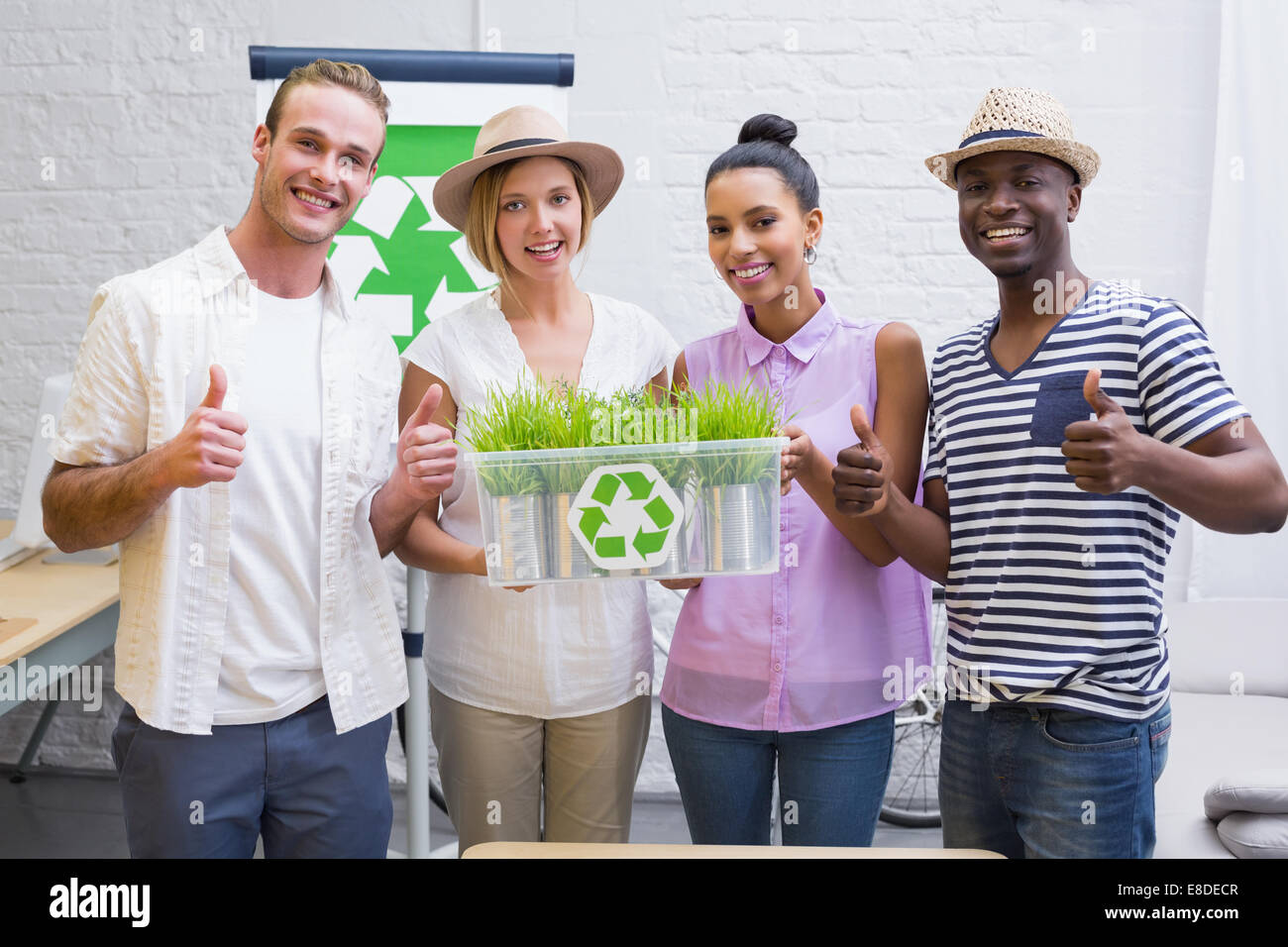 Creative business team holding plant with recycling symbol Stock Photo ...