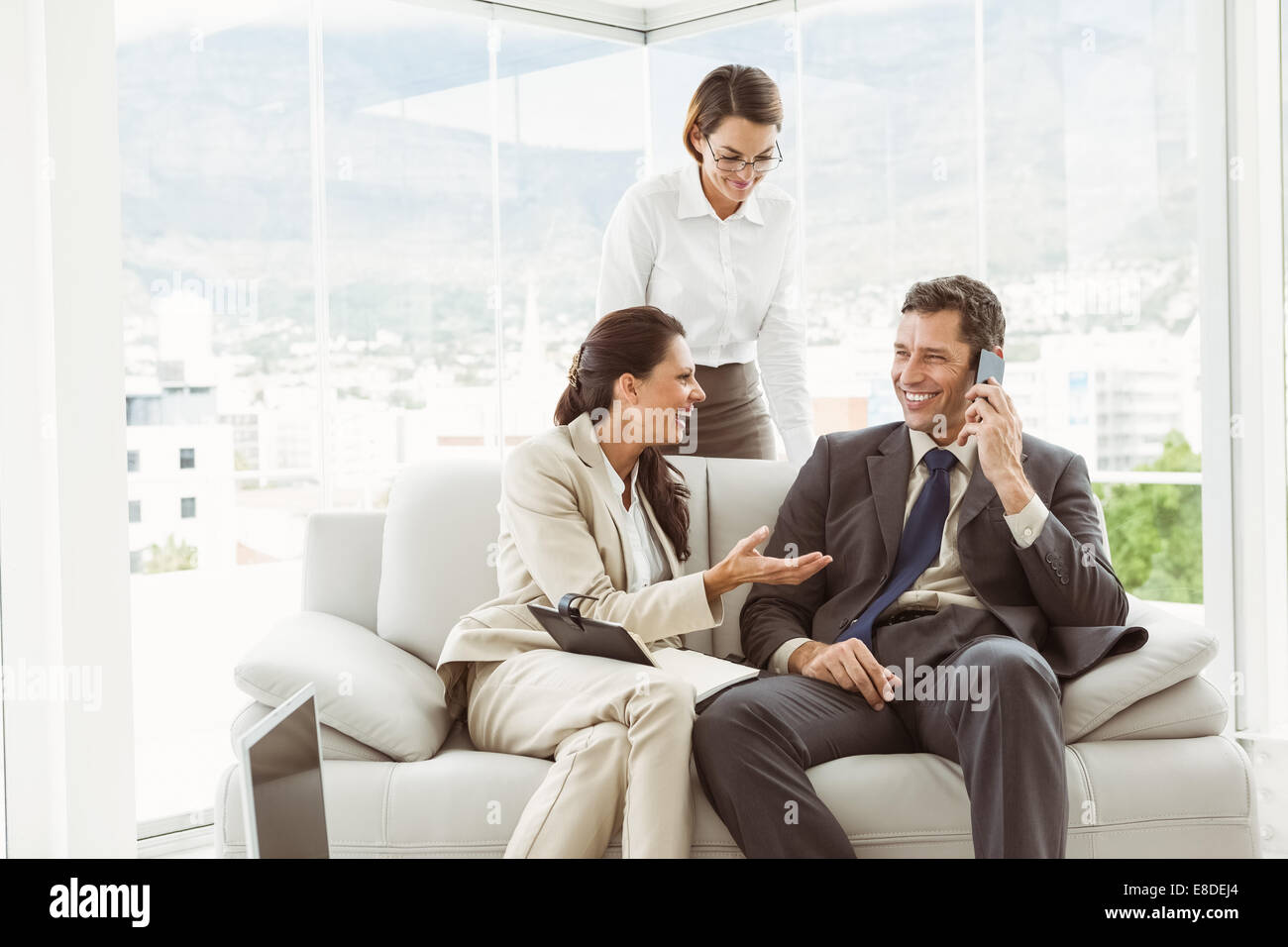 Business people in discussion in living room Stock Photo - Alamy