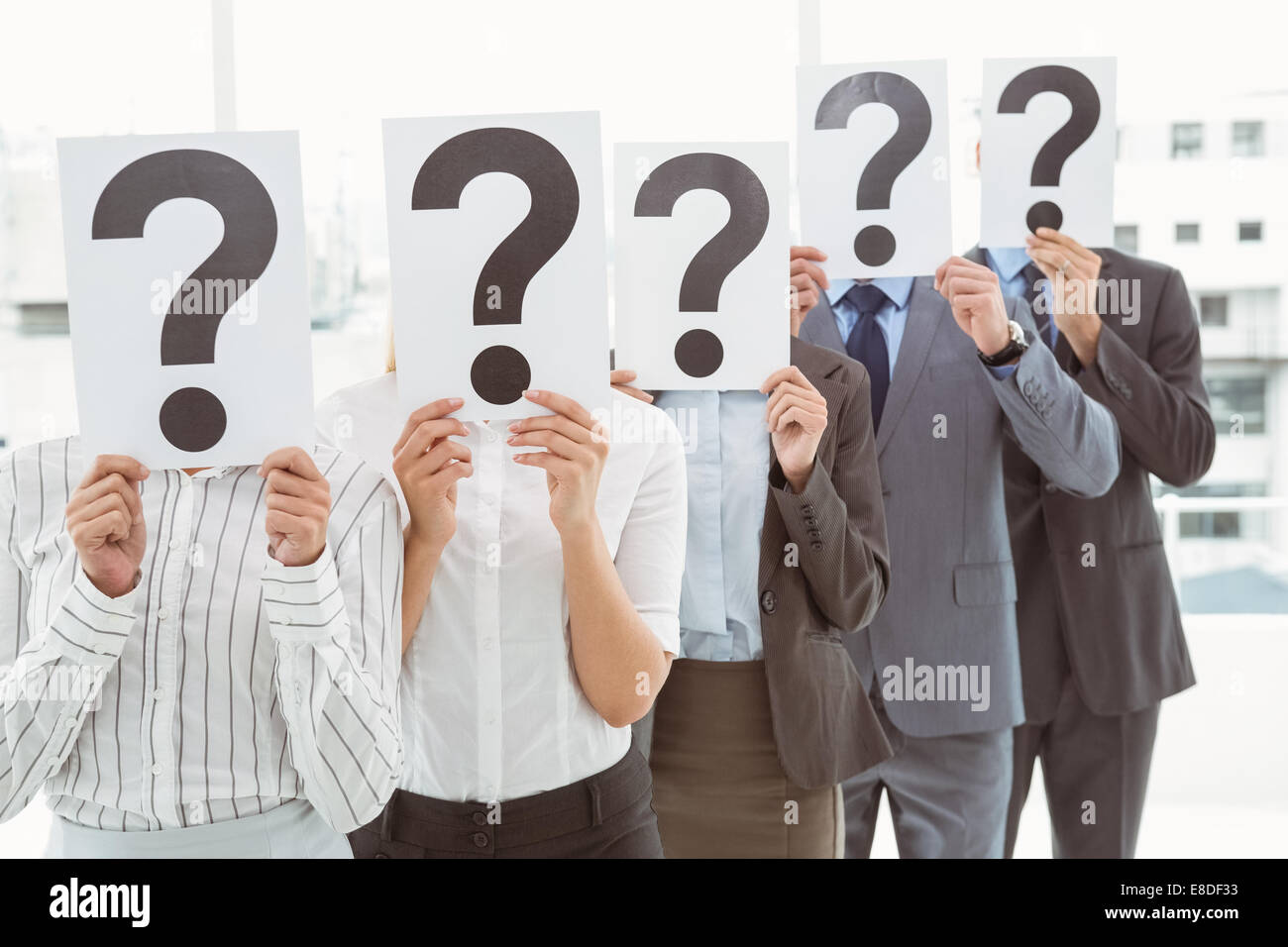 Business people holding question mark signs in office Stock Photo - Alamy
