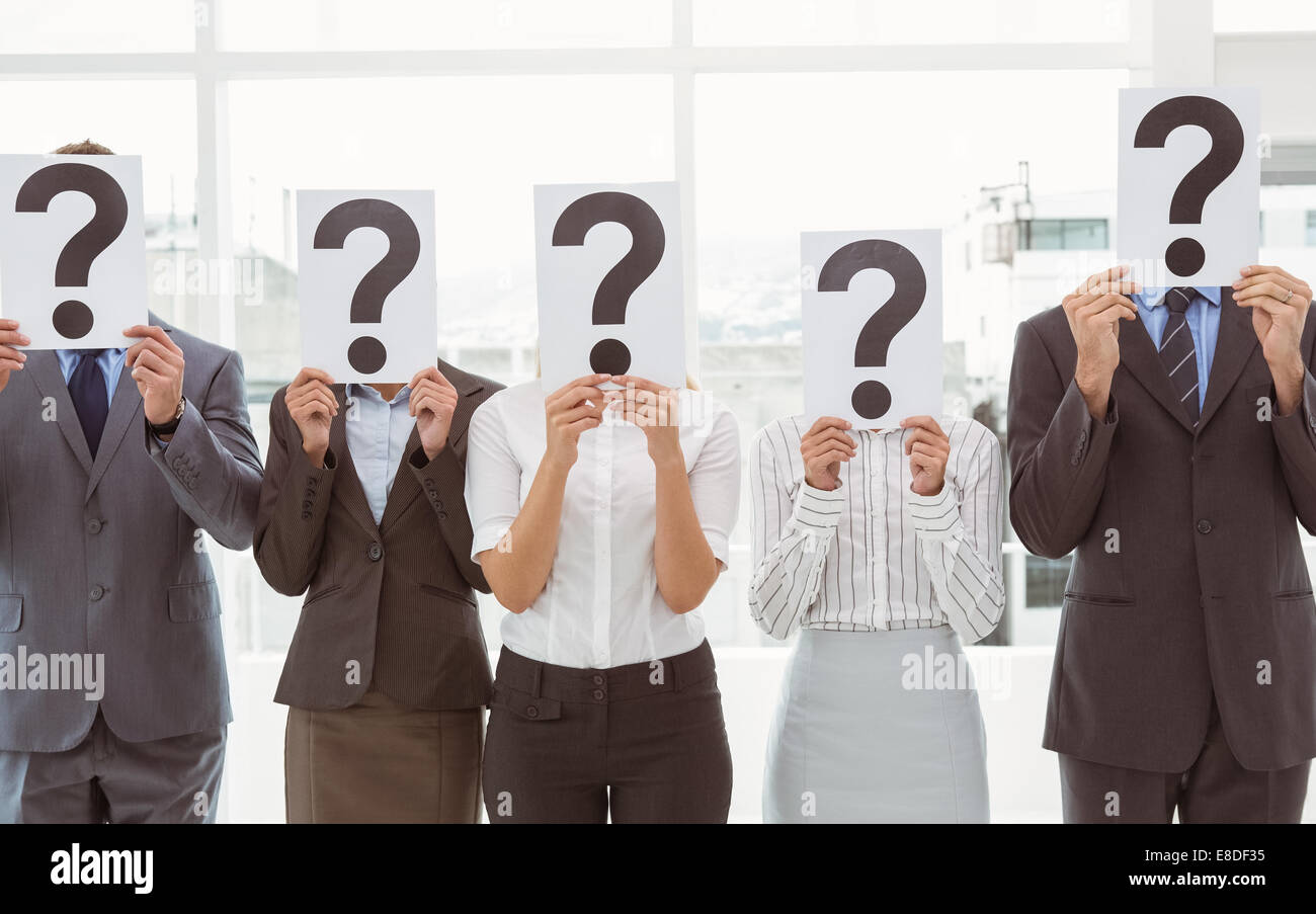 Business people holding question mark signs in office Stock Photo - Alamy