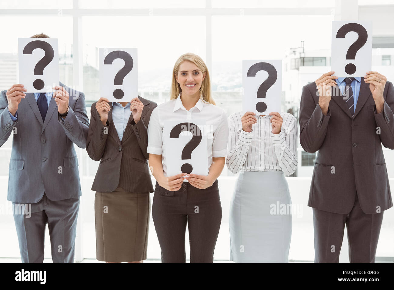 Business people holding question mark signs in office Stock Photo - Alamy