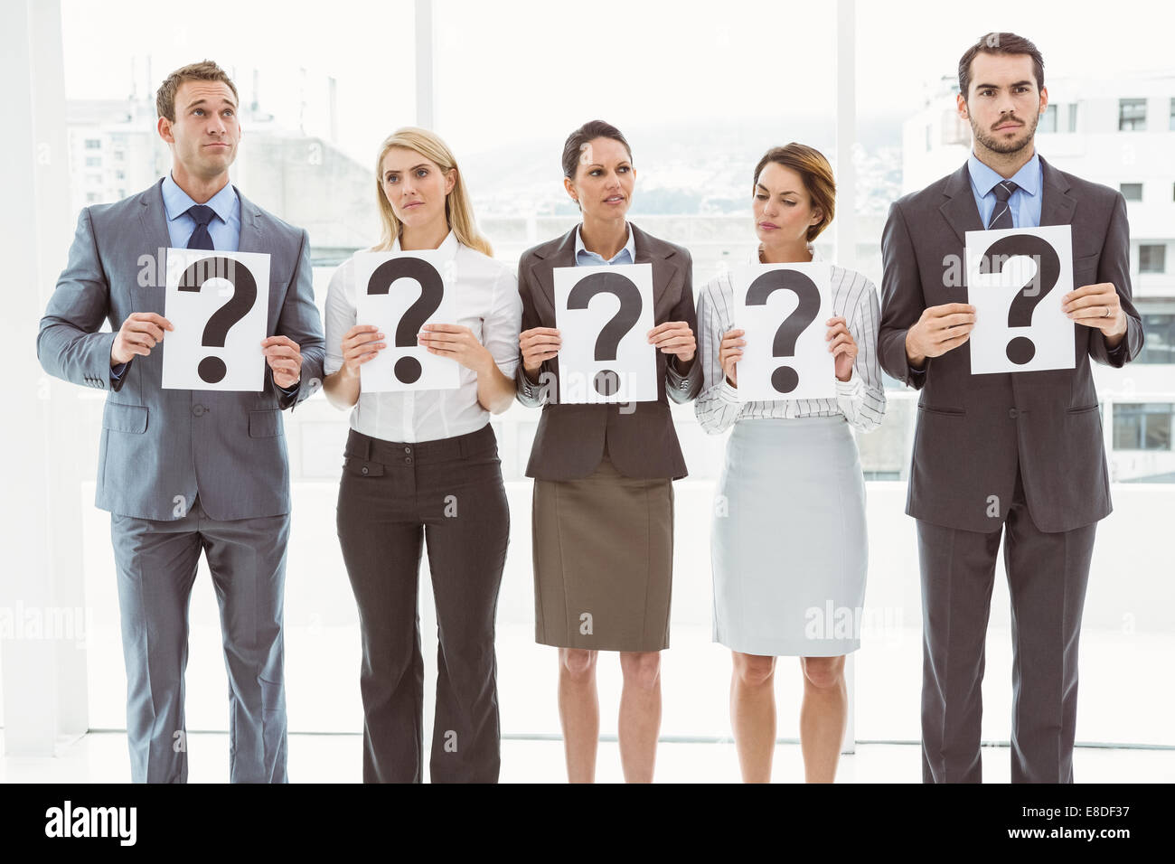 Business people holding question mark signs Stock Photo - Alamy