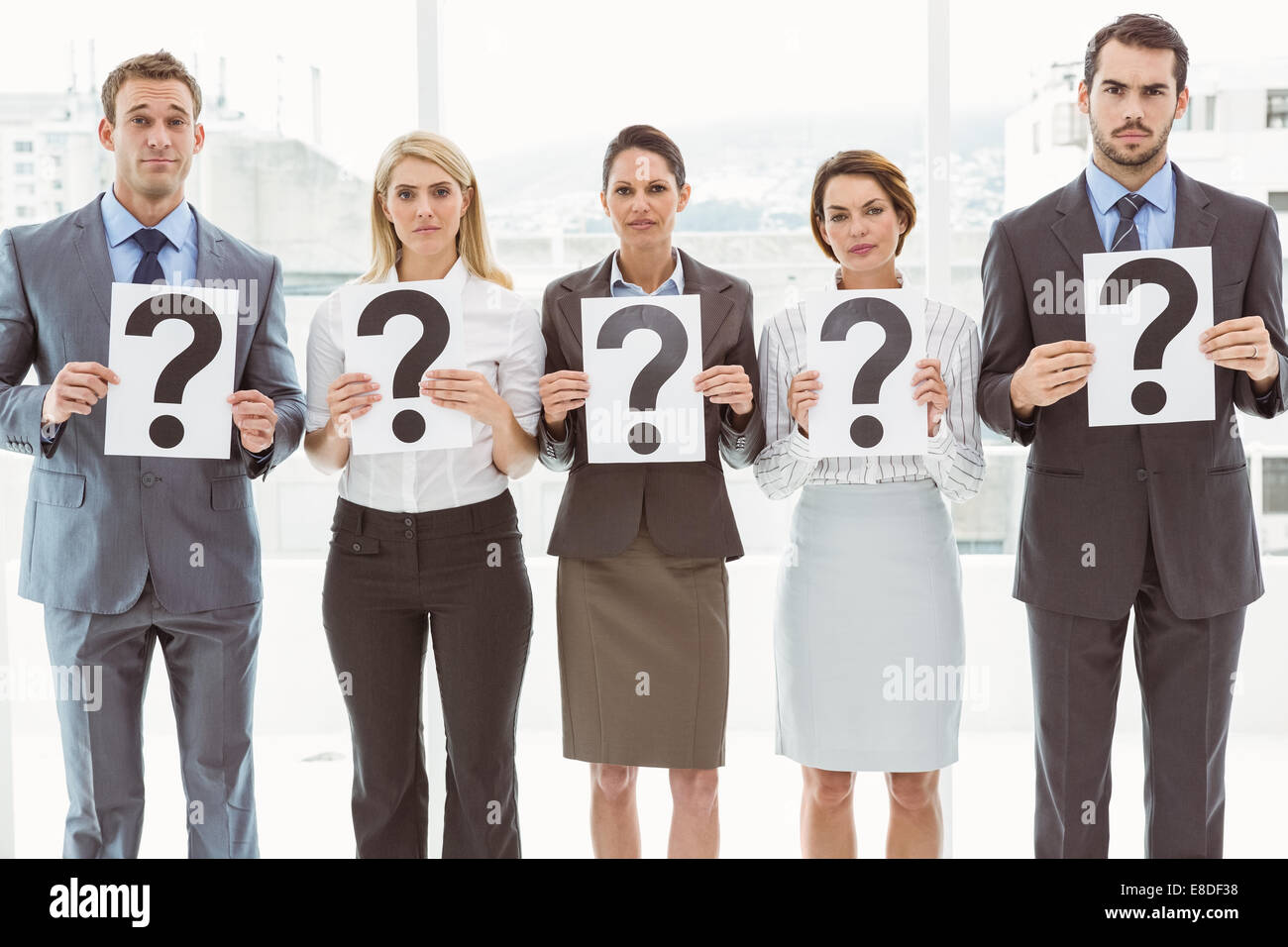 Business people holding question mark signs Stock Photo - Alamy