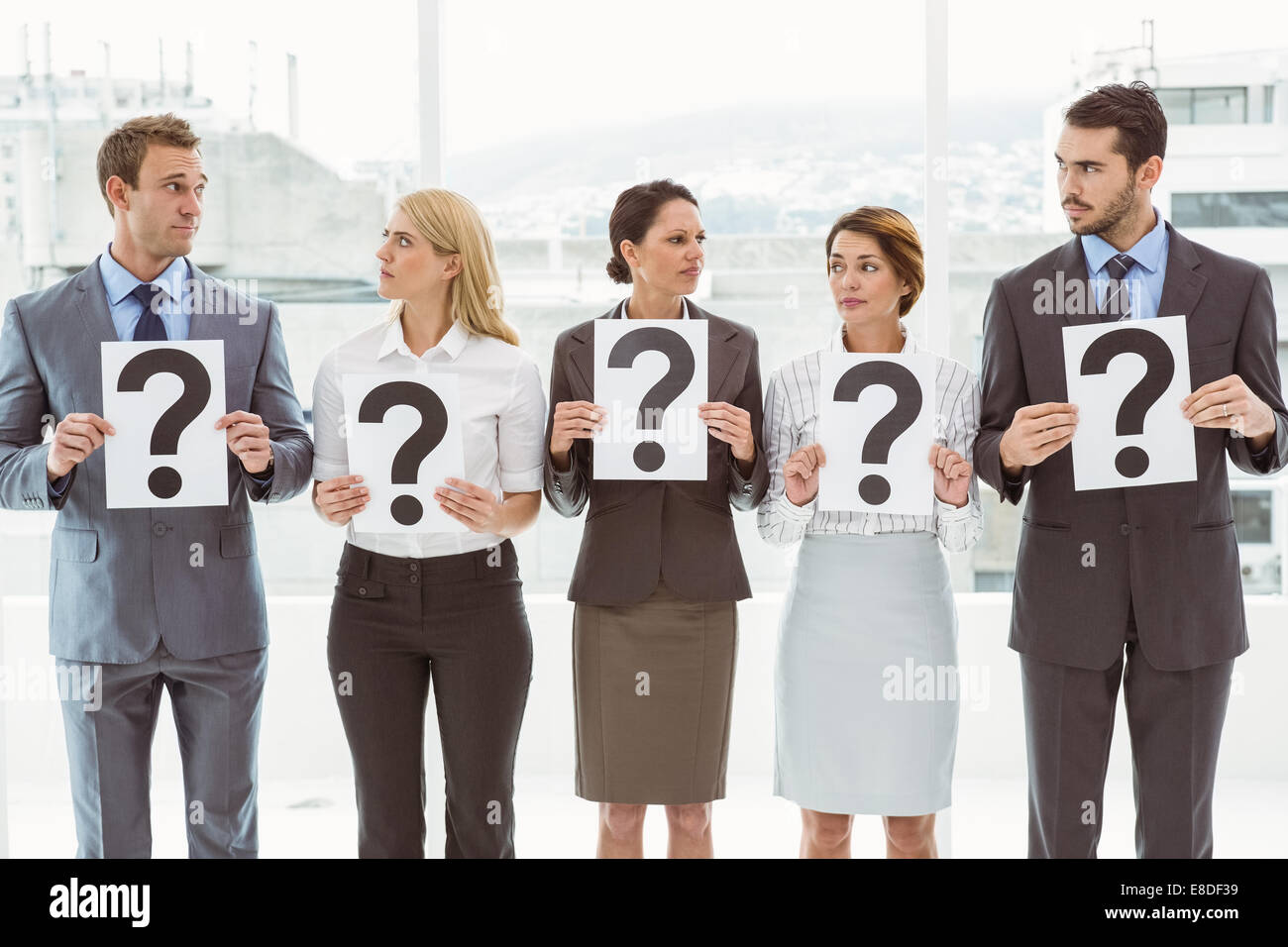 Business people holding question mark signs Stock Photo - Alamy