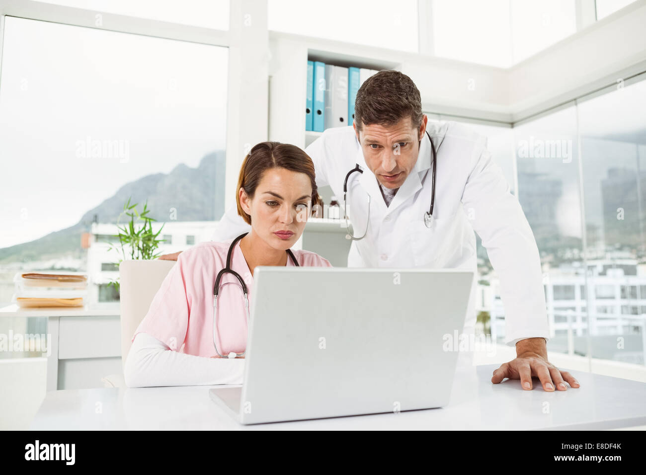 Doctors using laptop together at medical office Stock Photo - Alamy