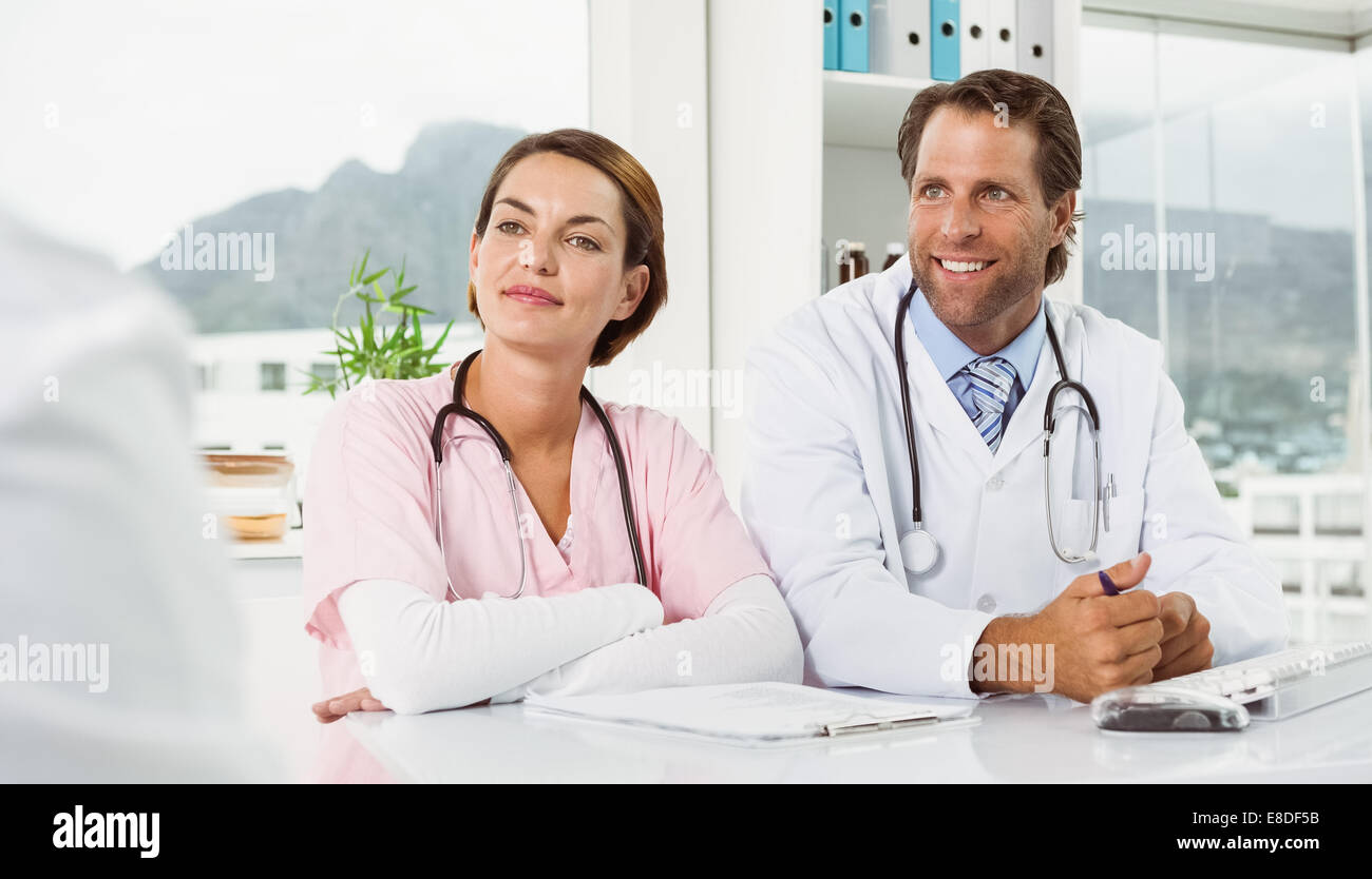 Doctors in discussion with patient in medical office Stock Photo - Alamy
