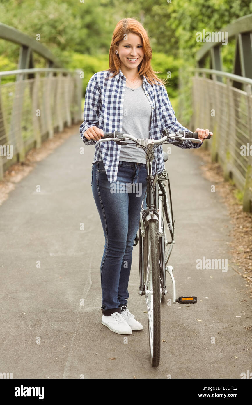 Pretty redhead with her bike smiling at camera Stock Photo - Alamy