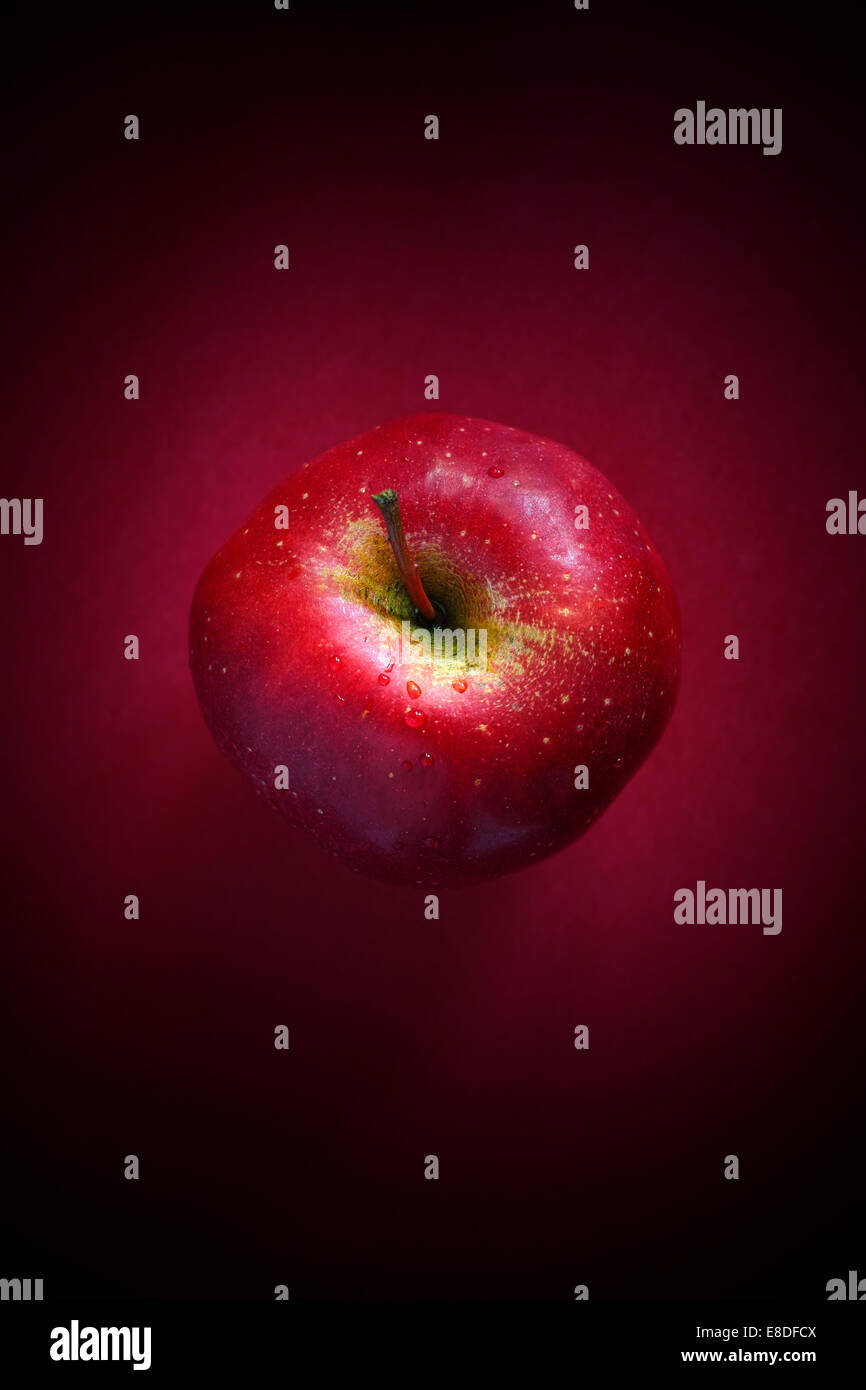 Red apple on red background Stock Photo - Alamy