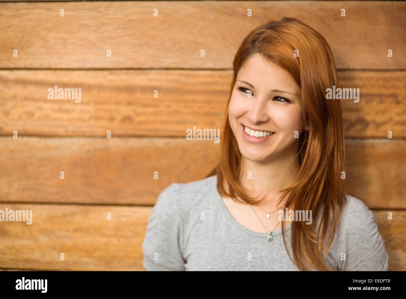 Pretty redhead smiling and thinking Stock Photo - Alamy