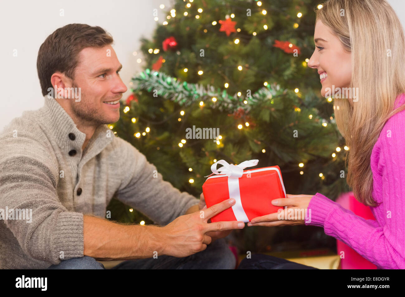 Sitting couple giving each other presents Stock Photo - Alamy