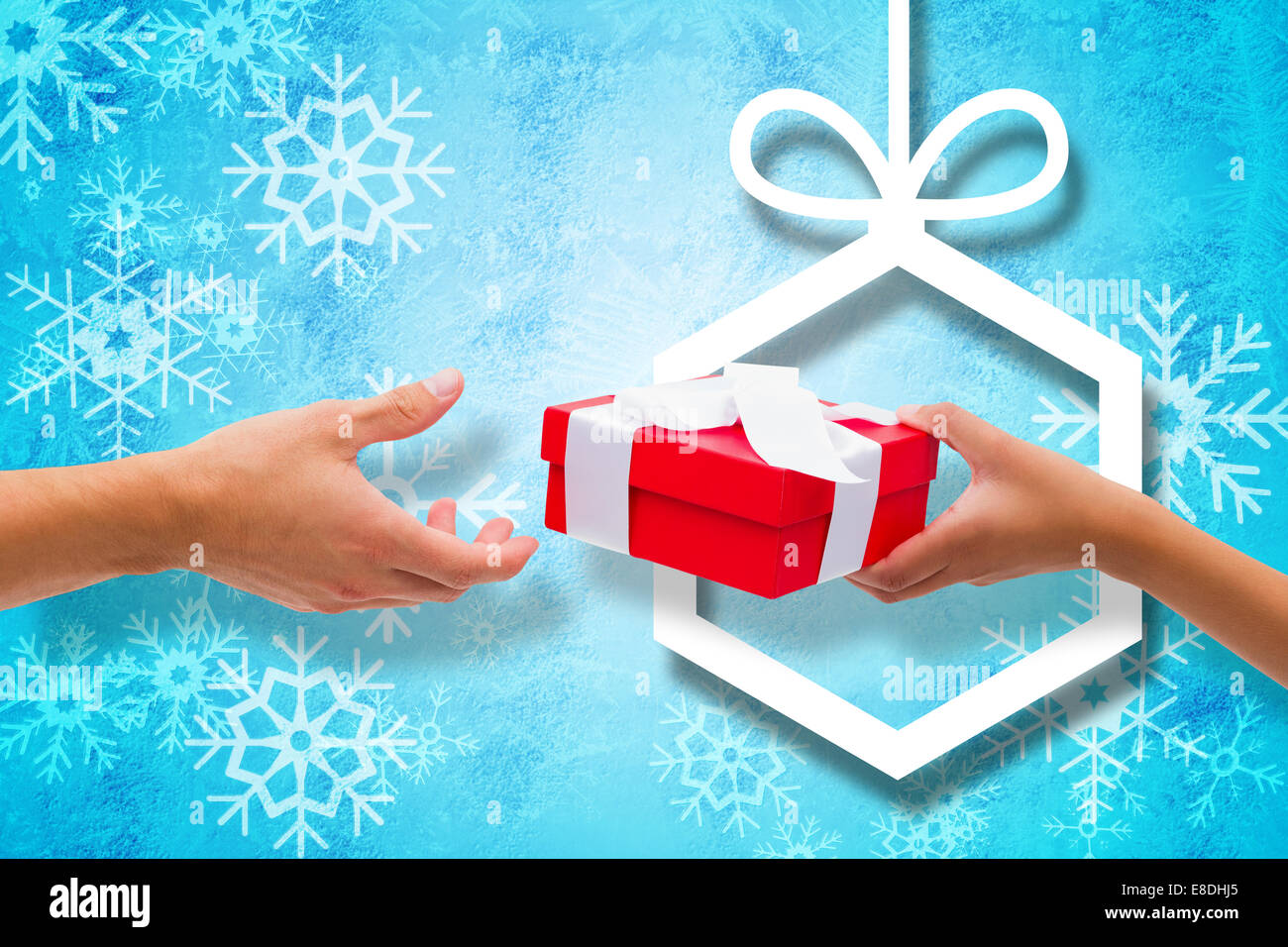 Composite image of couple passing a wrapped gift Stock Photo - Alamy